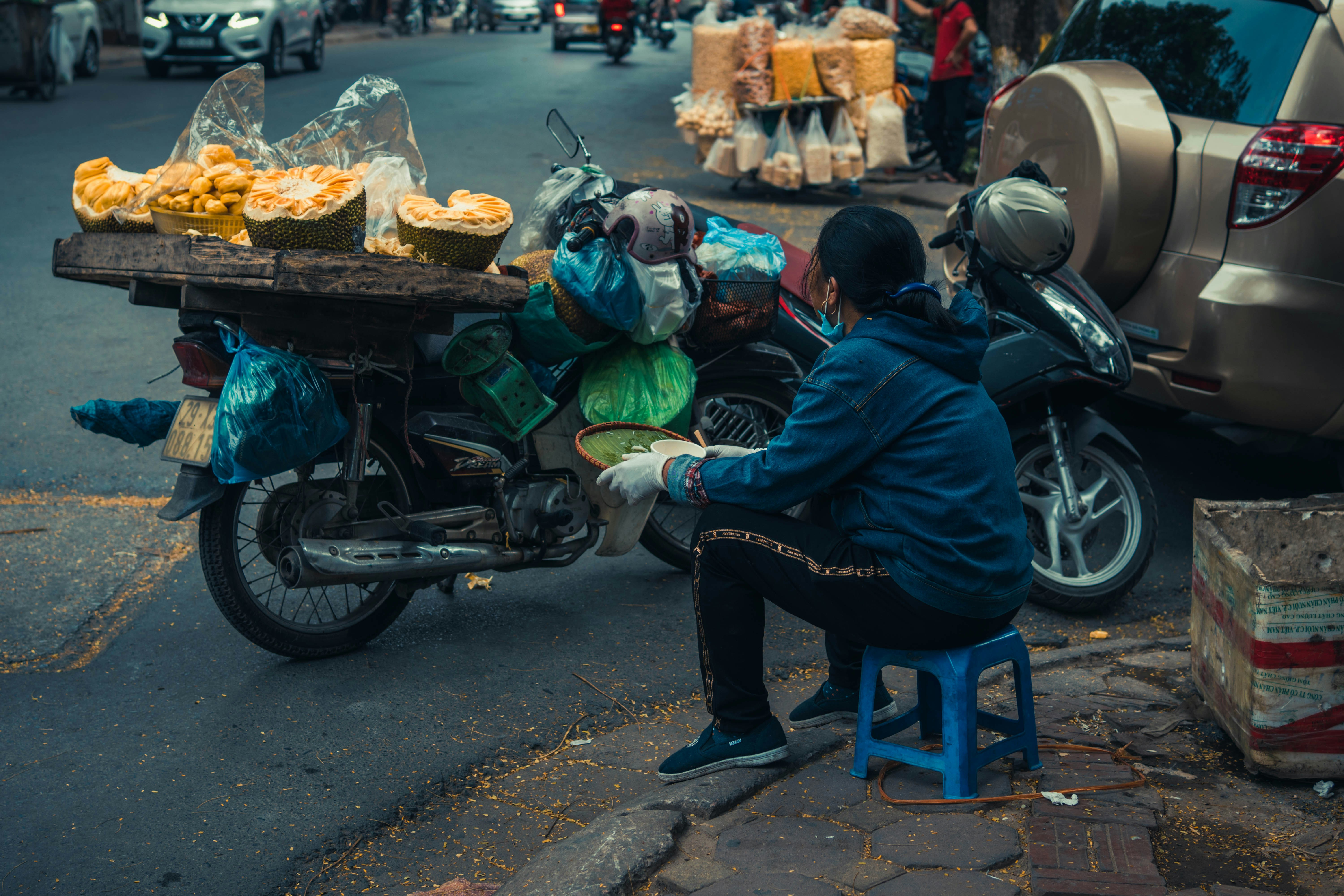 a person sitting on a stool next to a motorcycle