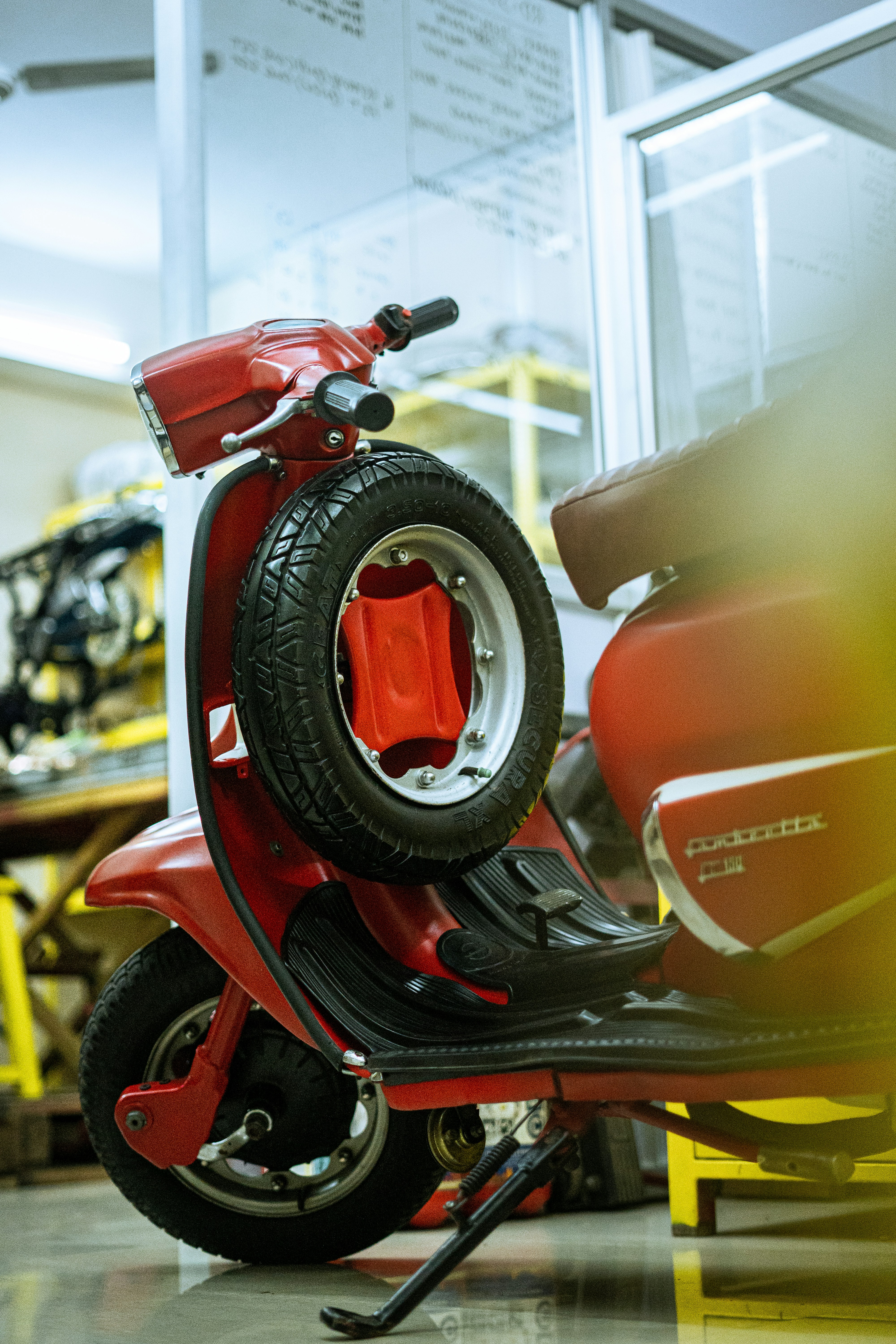 A red scooter is parked in a garage photo – Free Motor scooter Image on ...