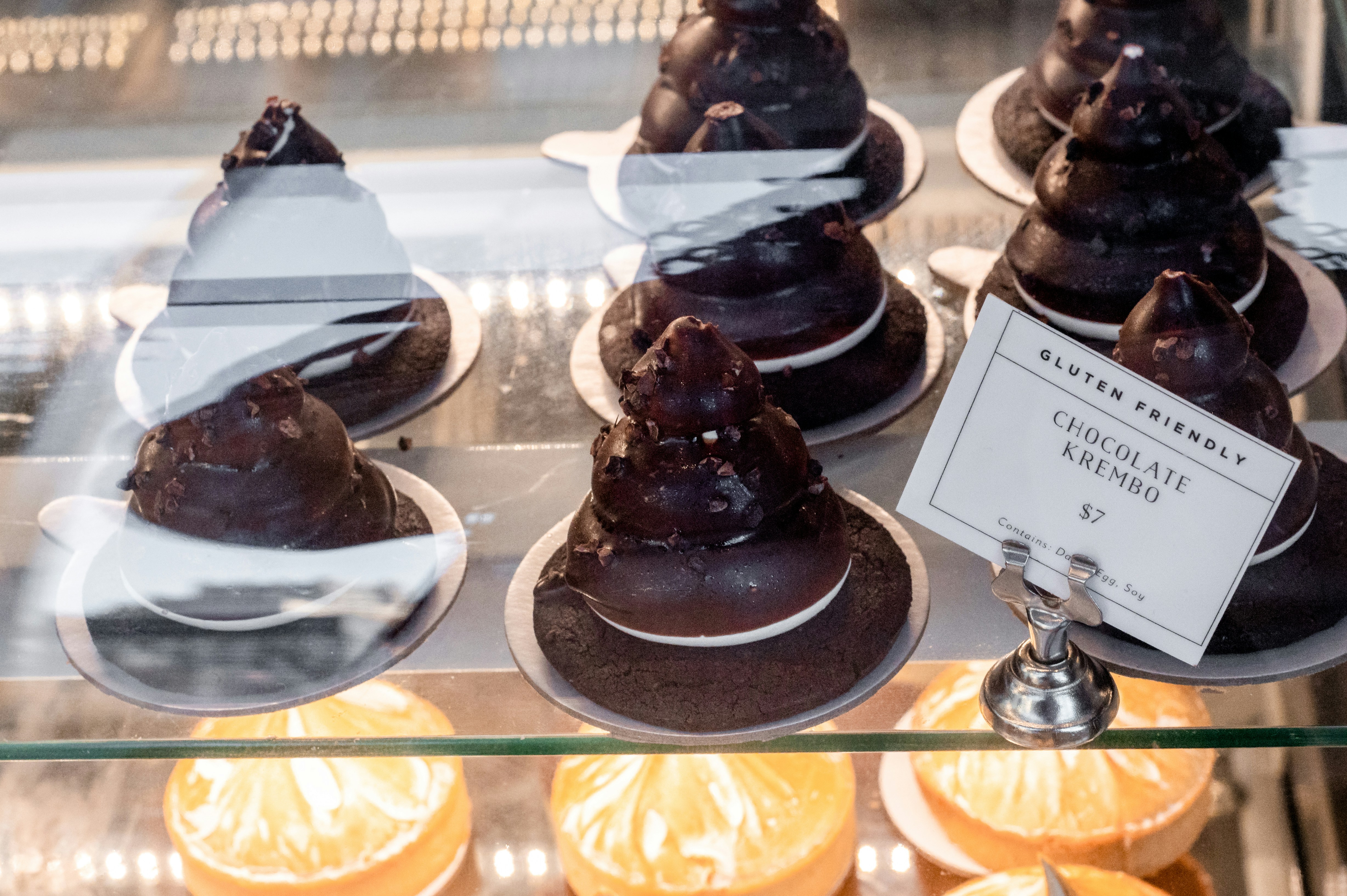A display case filled with lots of different types of cakes photo ...
