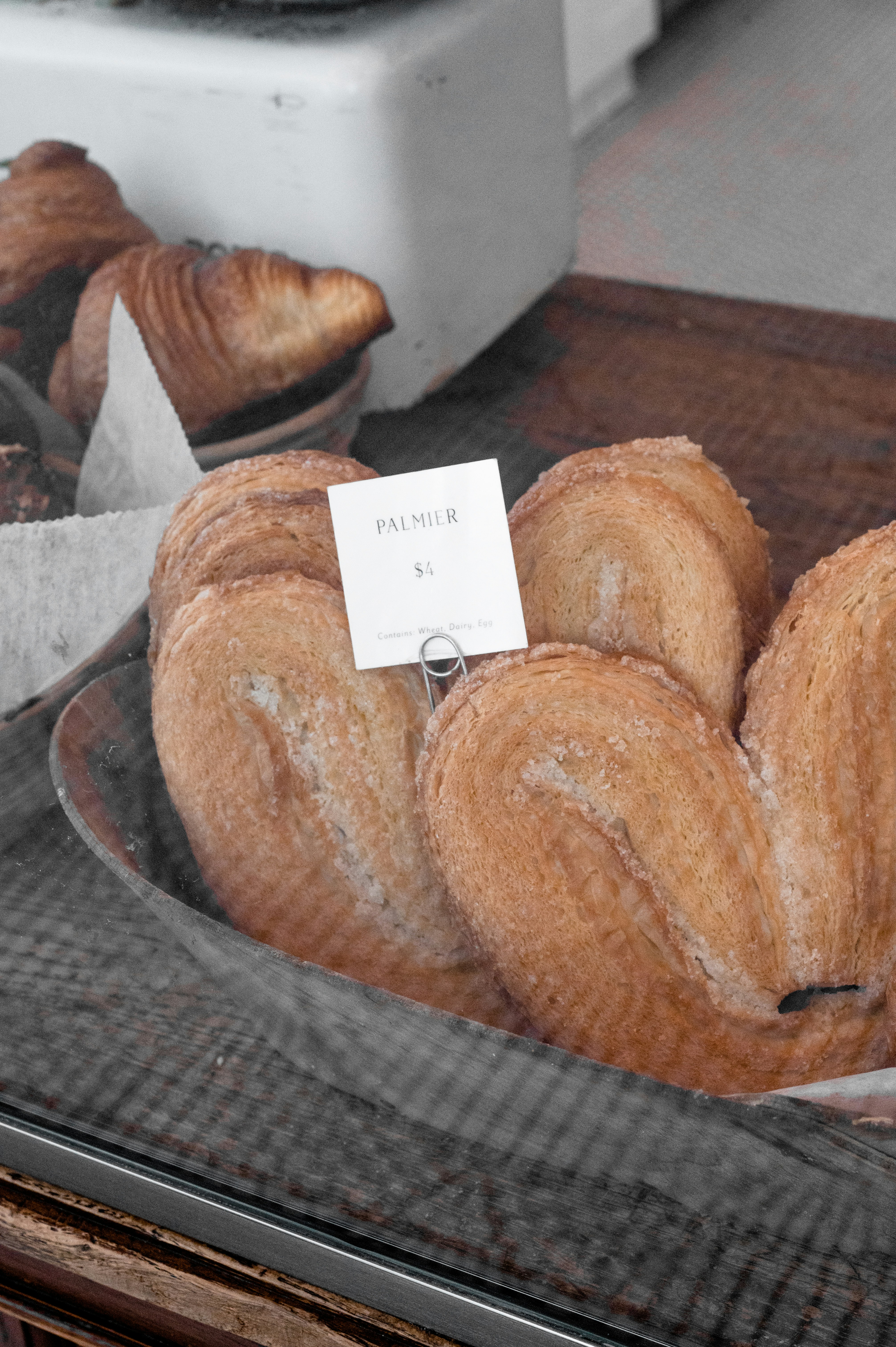 Crunched Crusts Under Glass: A Bakery Display of Palmier Scrolls