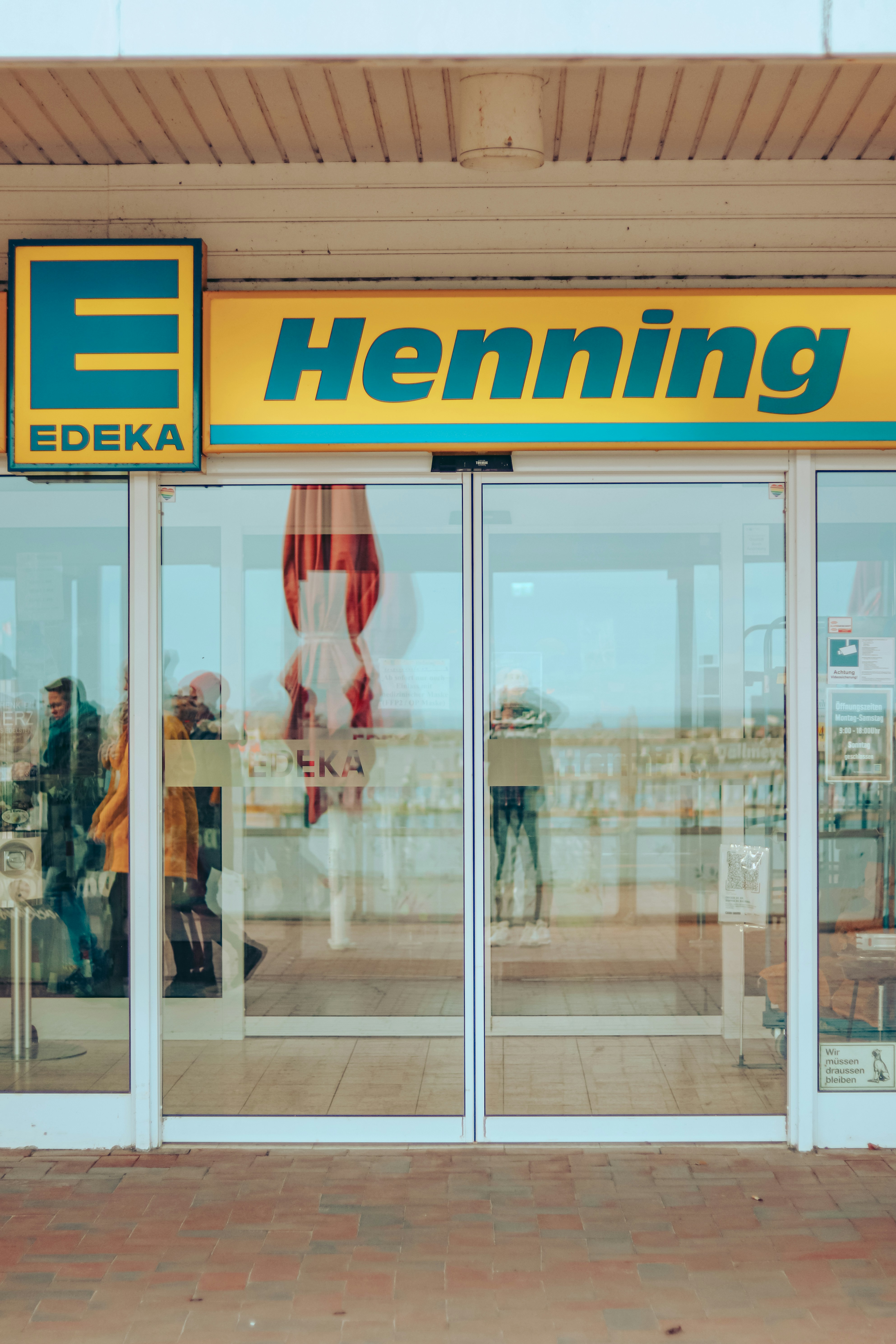 a store front with a few people walking in front of it