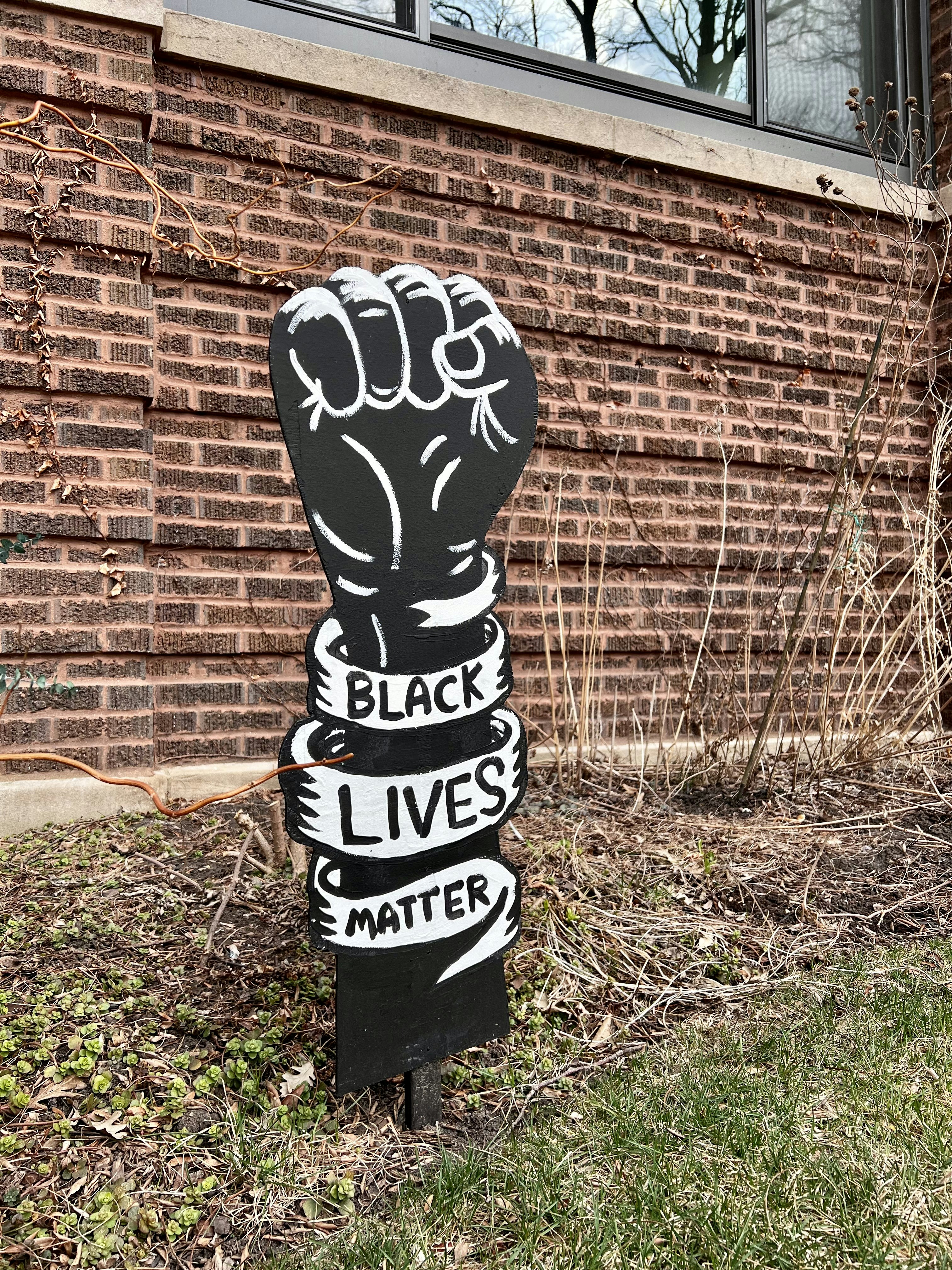a black lives matter sign in front of a brick building