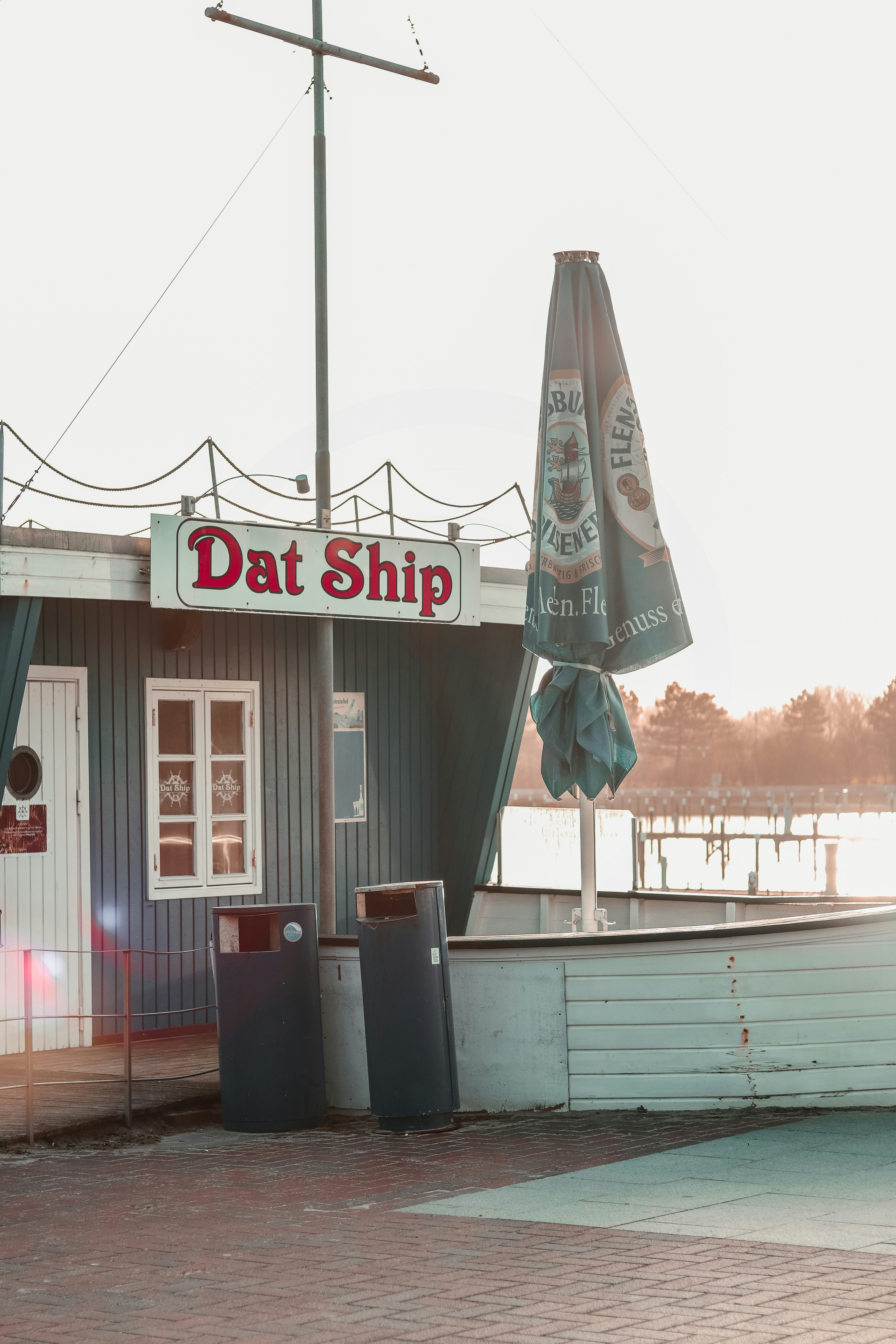 Dat Ship at the Docks: A Quiet Lakeside Shack Beneath Soft Sunset