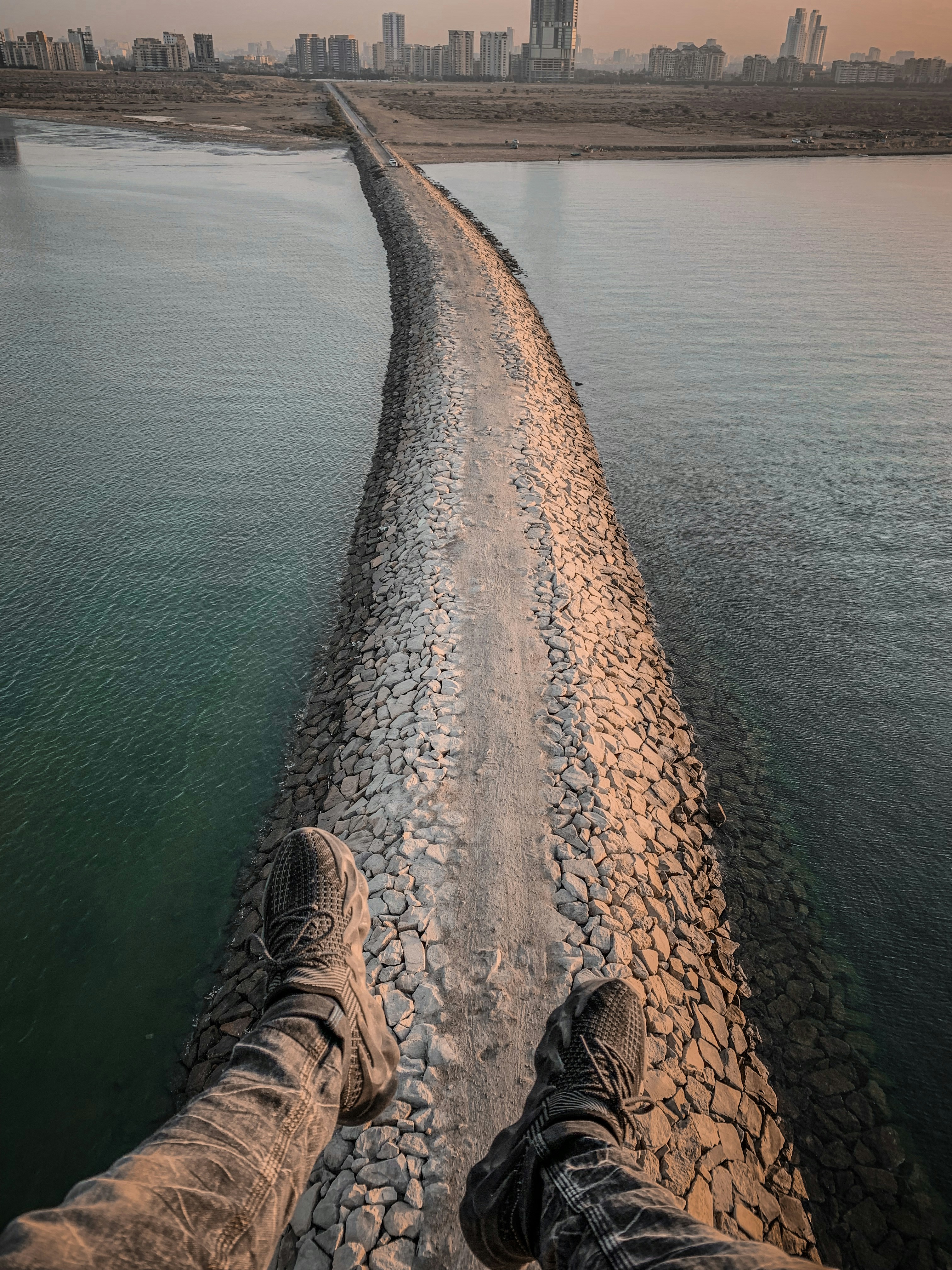 Stone Ribbon to the City: A Narrow Causeway Framing Distant Skyscrapers