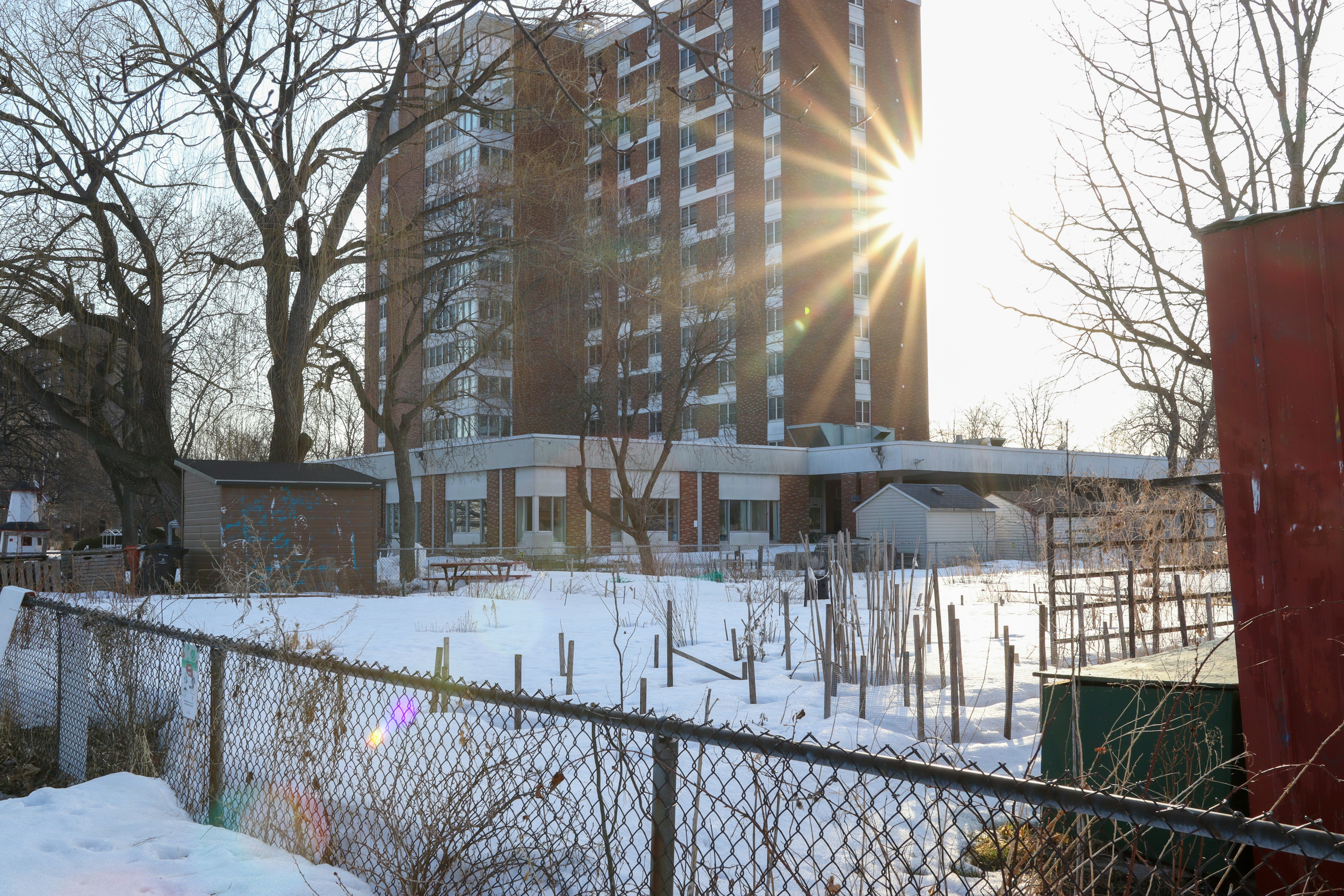 The sun shines brightly through the buildings in the snow photo – Free ...
