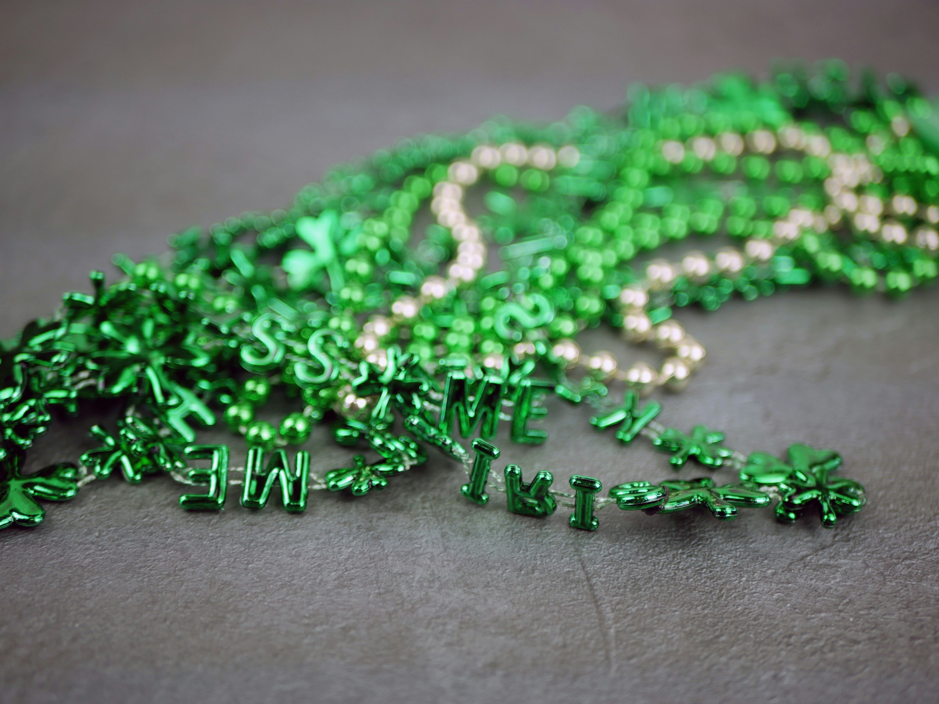 A bunch of green beads laying on top of a table photo – Free Green ...