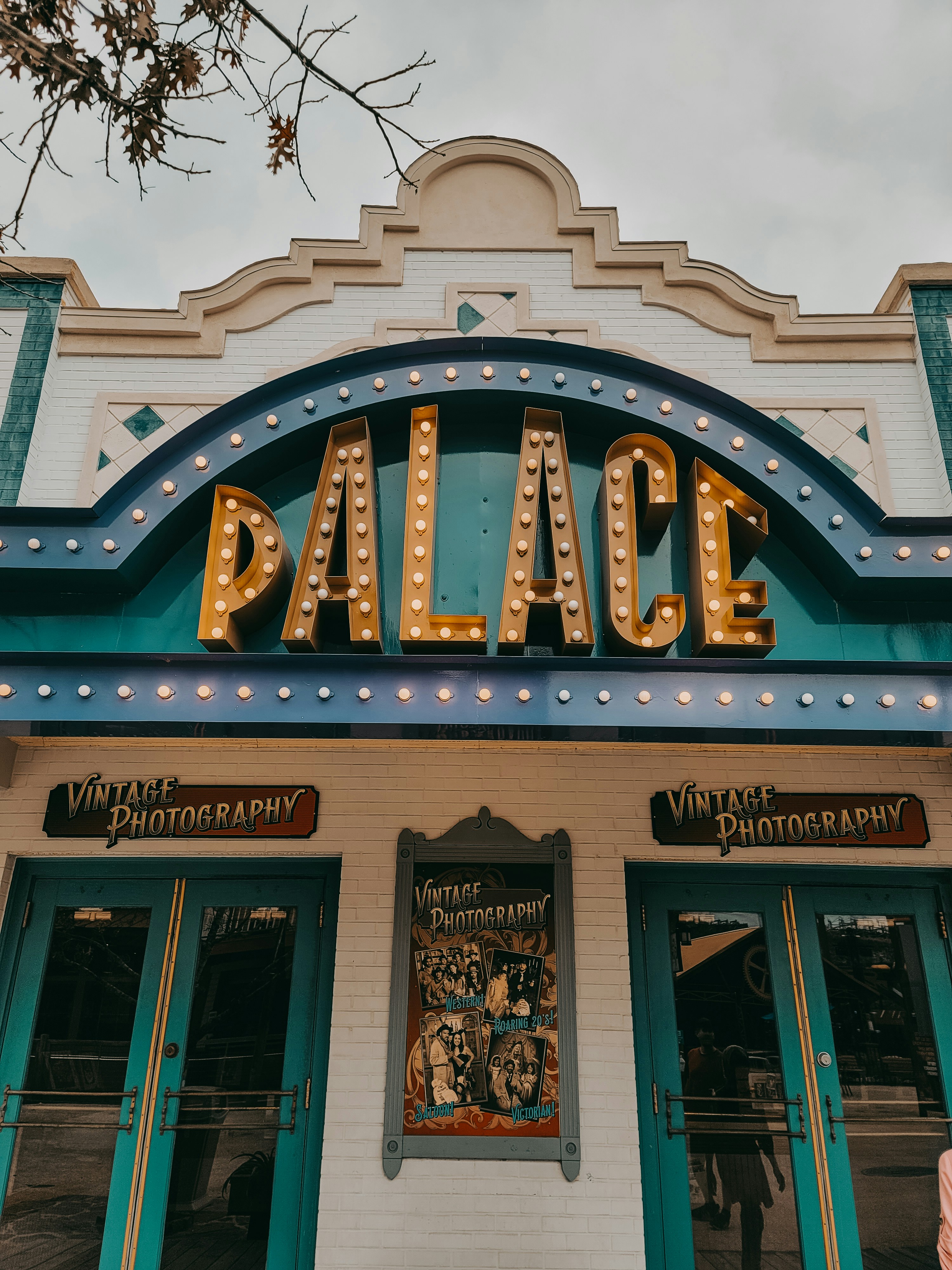 Neon Palace façades: teal doors beneath marquee lights