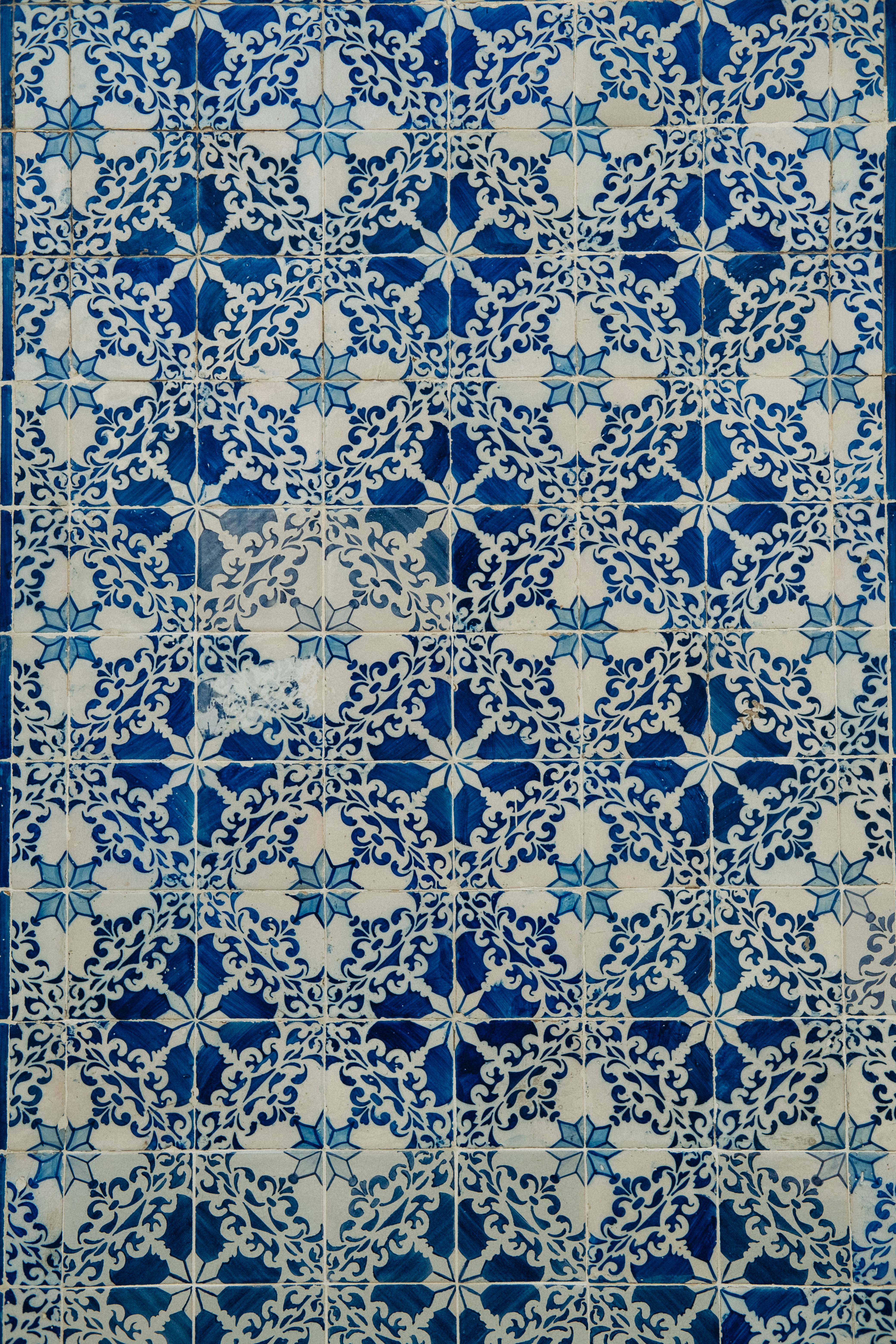 Intricate blue and white tile design showcasing a symmetrical pattern reminiscent of traditional craftsmanship.