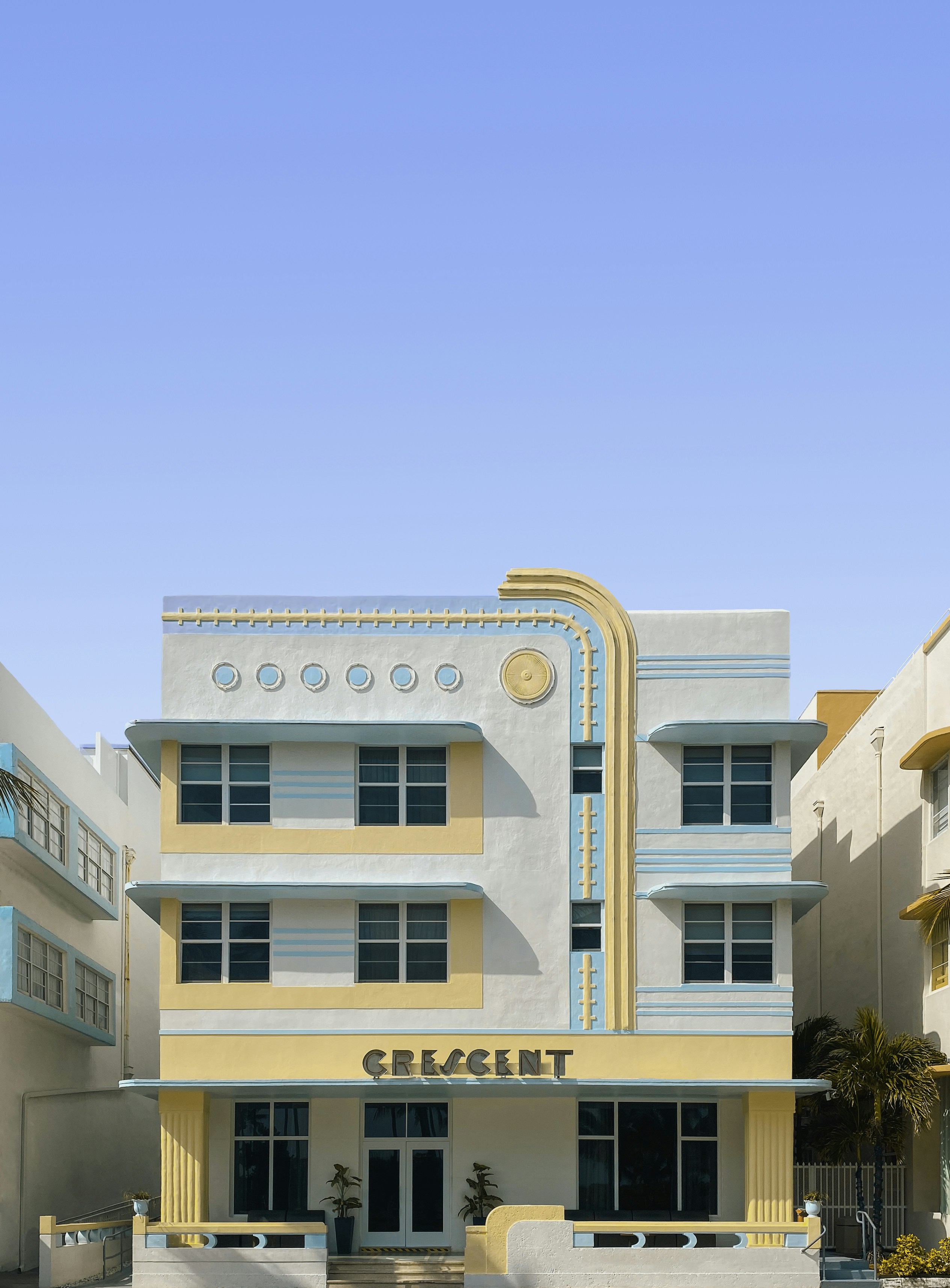 Art Deco-style building featuring bold geometric lines and pastel colors, showcasing the iconic Crescent sign at its entrance.