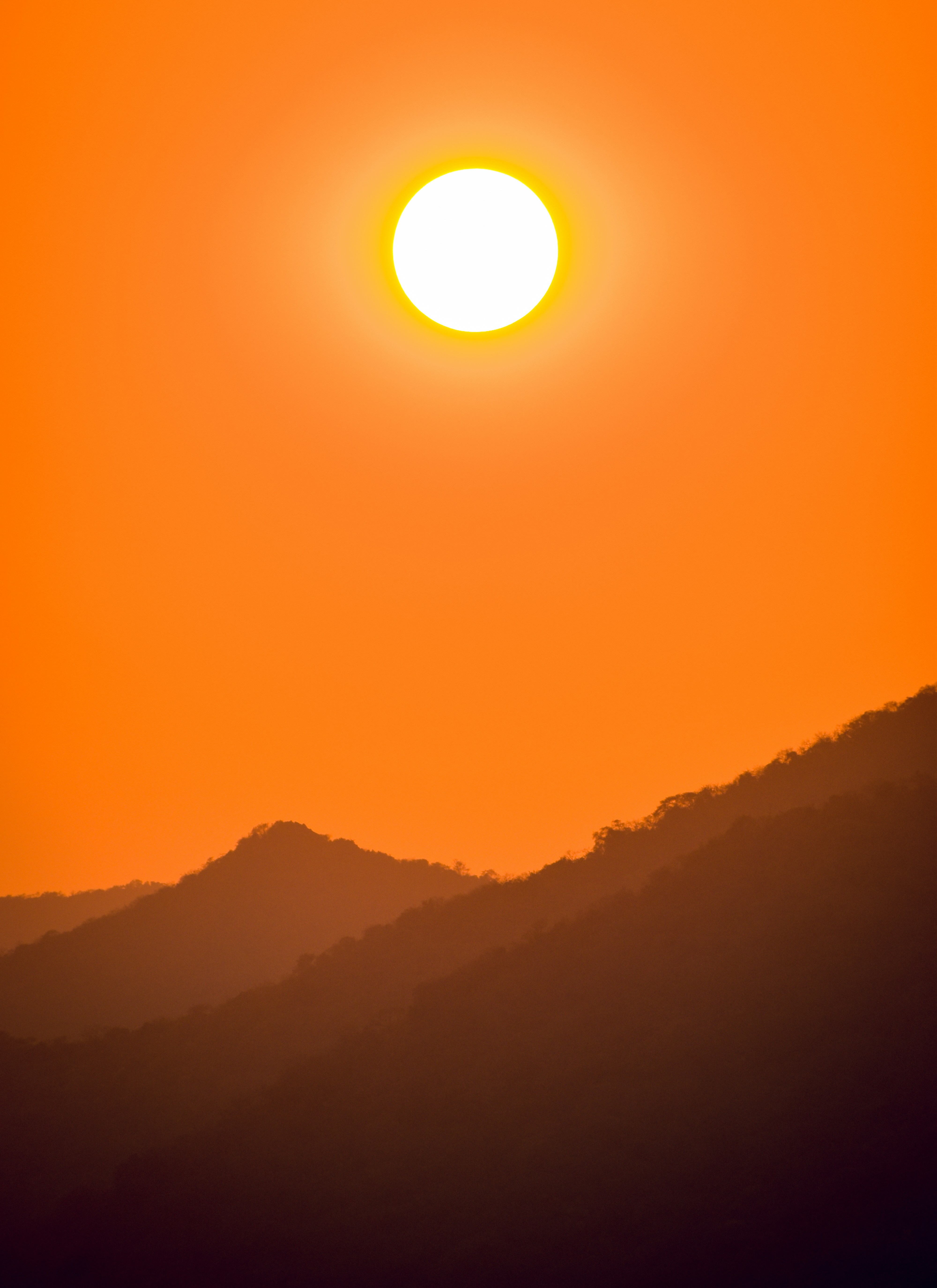 Crimson Sun Anchors a Layered Ridge at Dusk