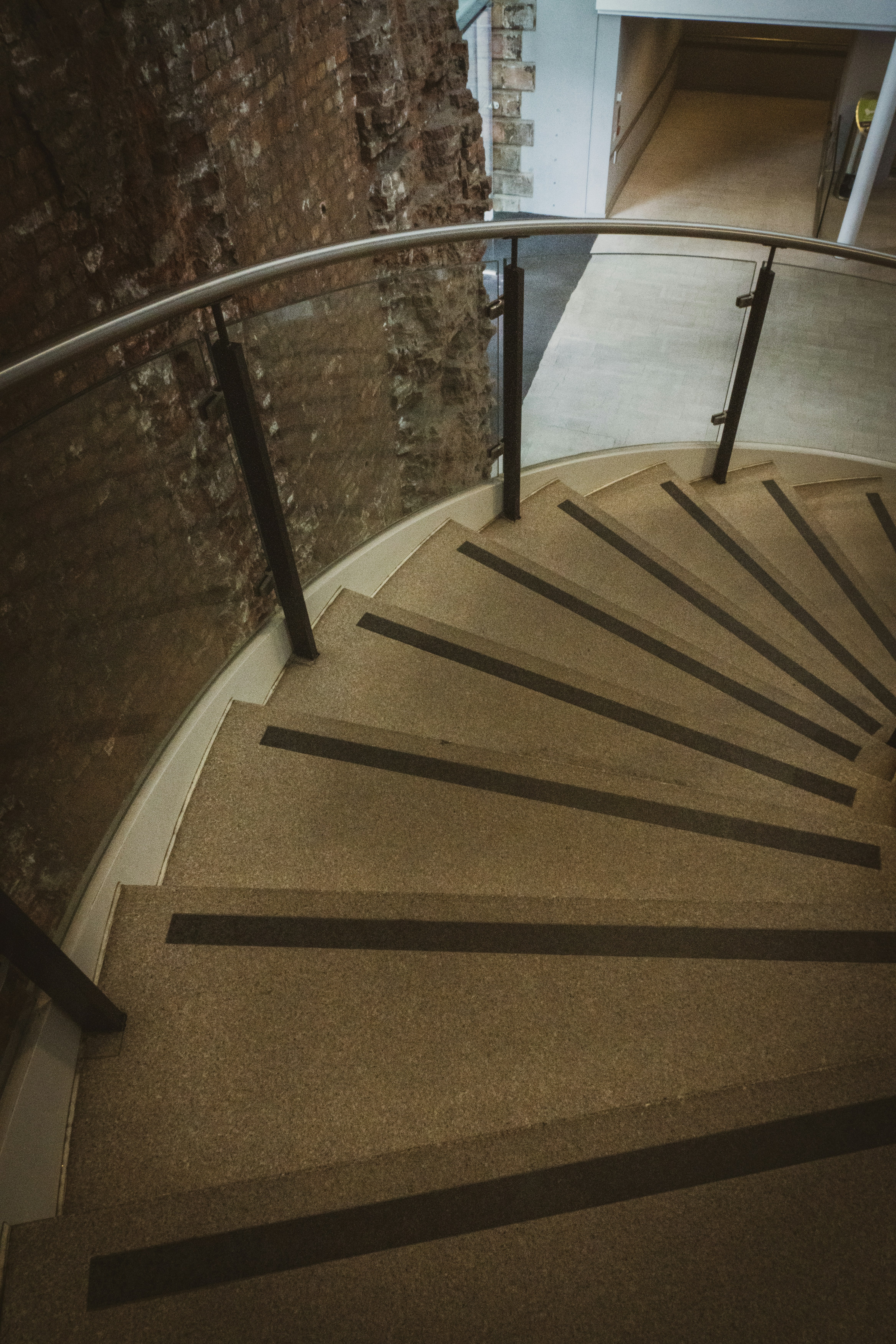 Concentric Descent: A Brick-Walled Spiral Staircase Curves Toward Light