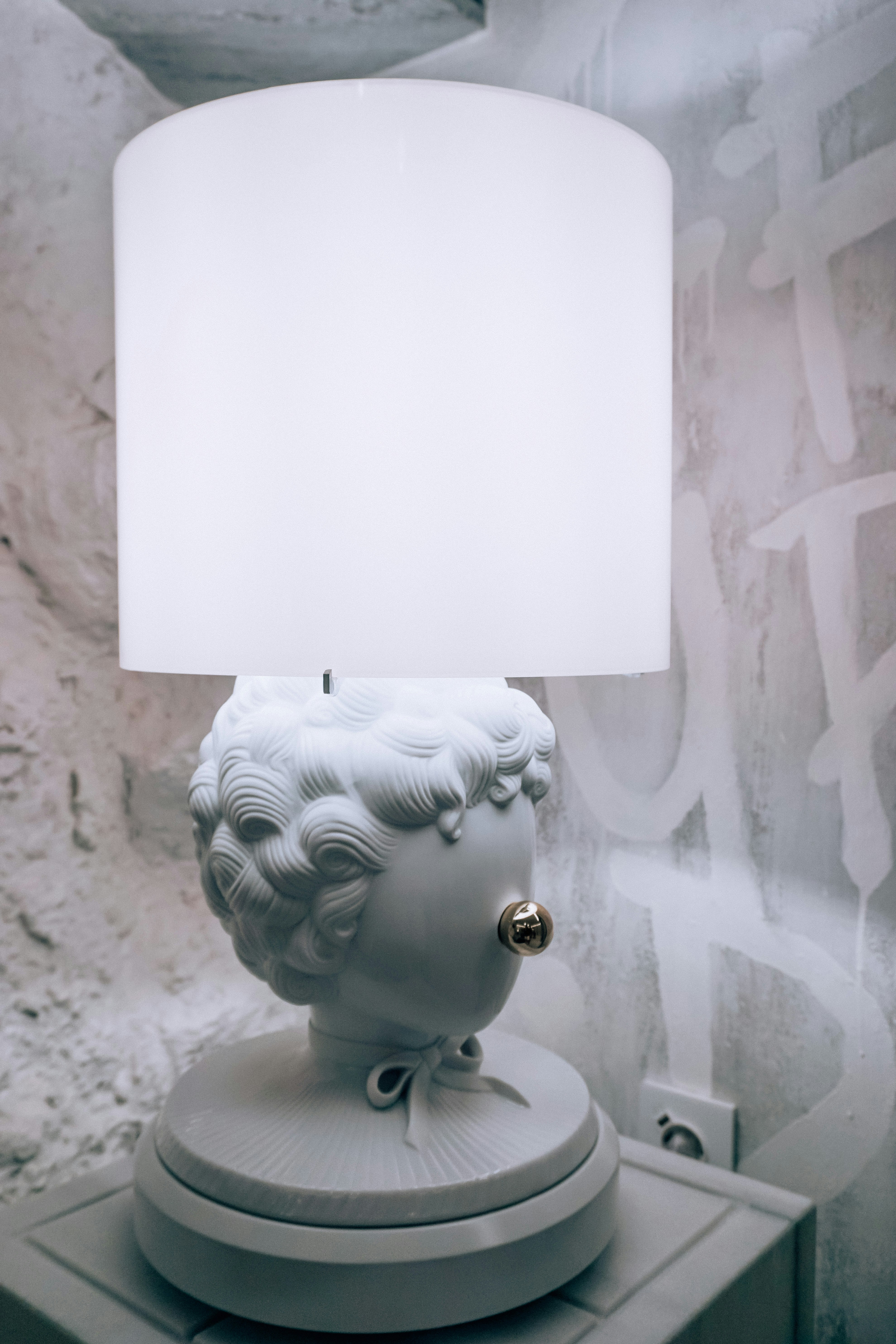White Cortège: A Ceramic Bust Lamp Cast in Soft Light