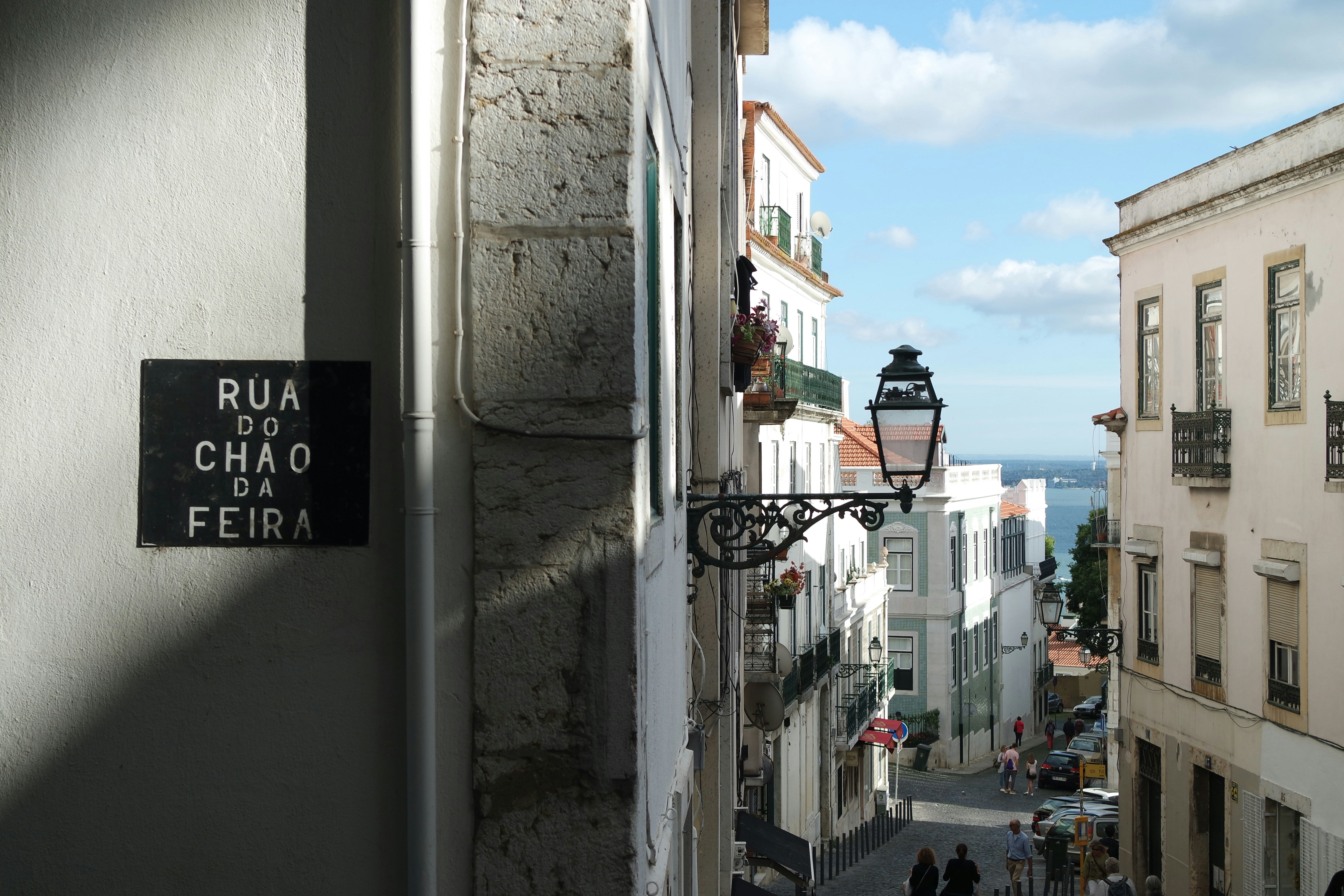 Descent to the Sea: Sunlit Portuguese Street with Pastel Facades
