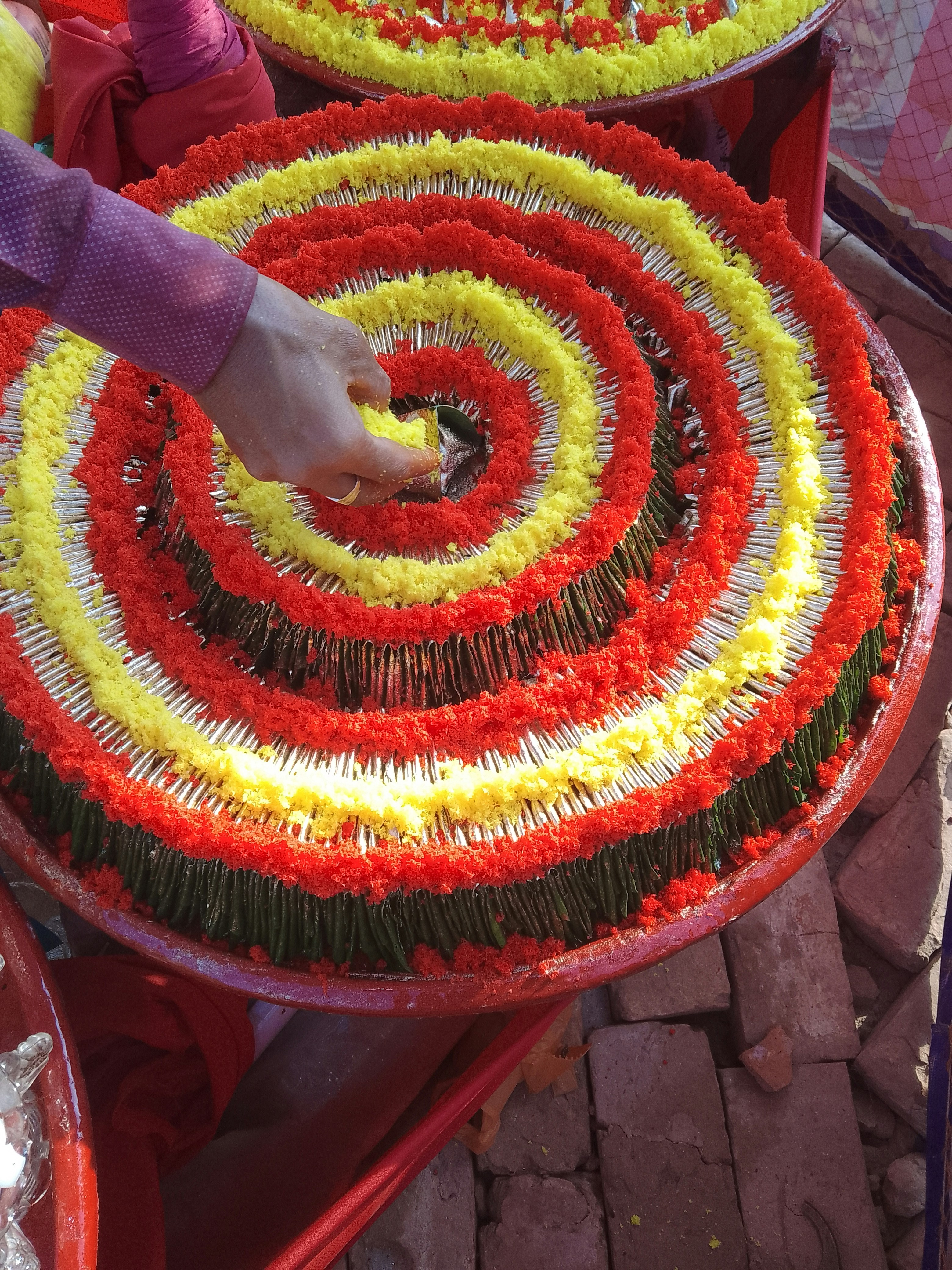 a person reaching for a piece of art made out of flowers