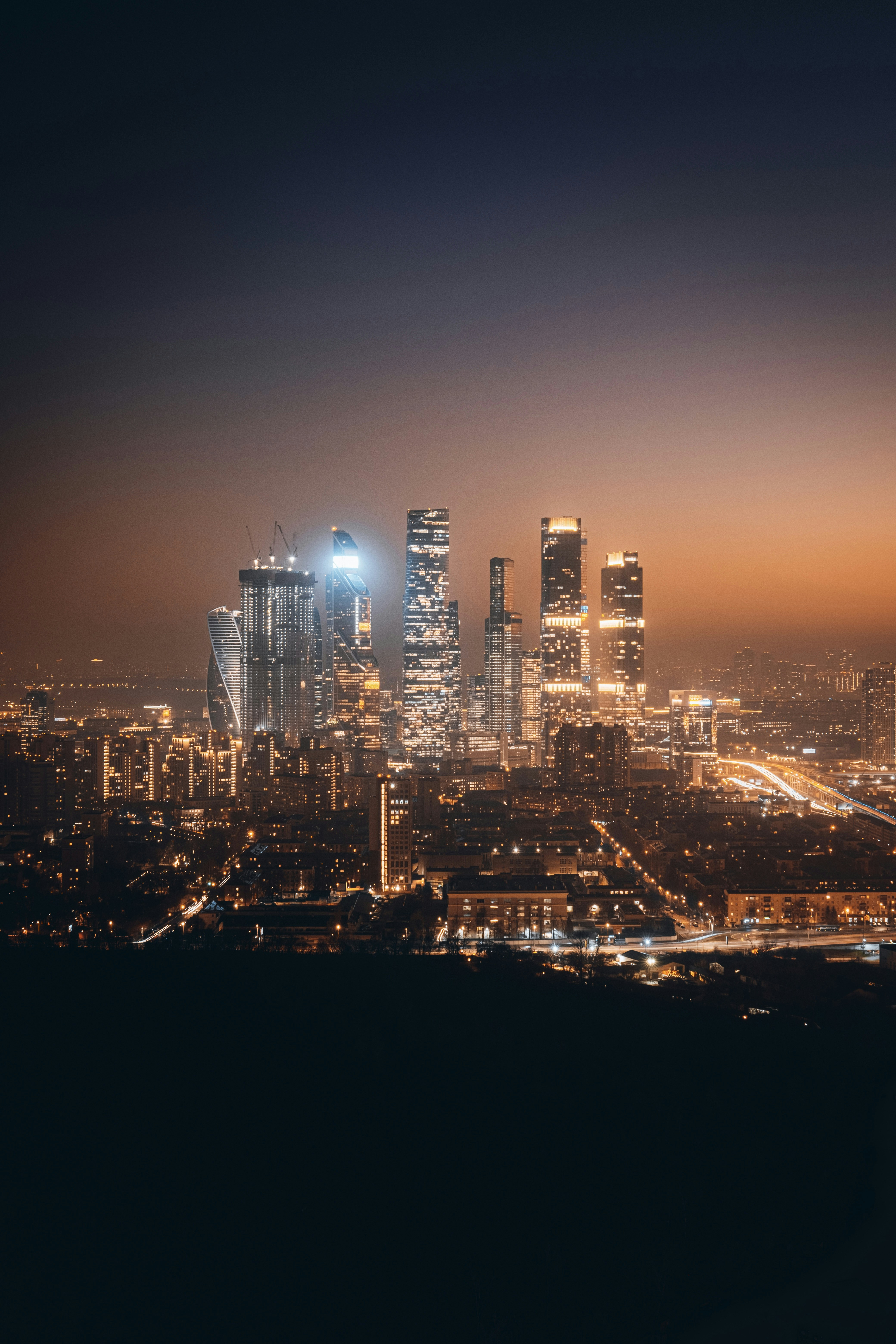 Neon Spine: Night skyline of glass towers rising over a molten horizon
