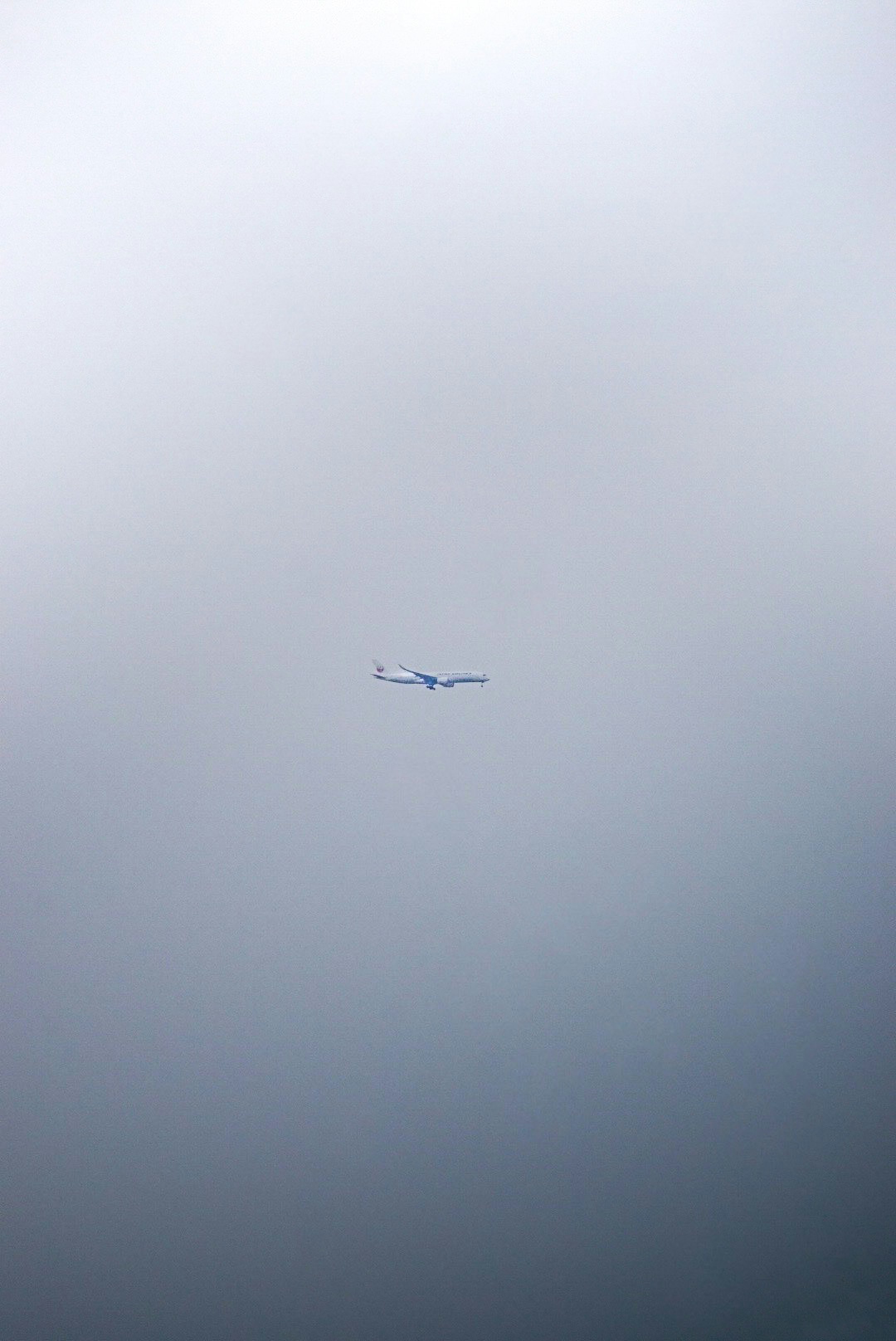 An airplane flying through a cloudy sky