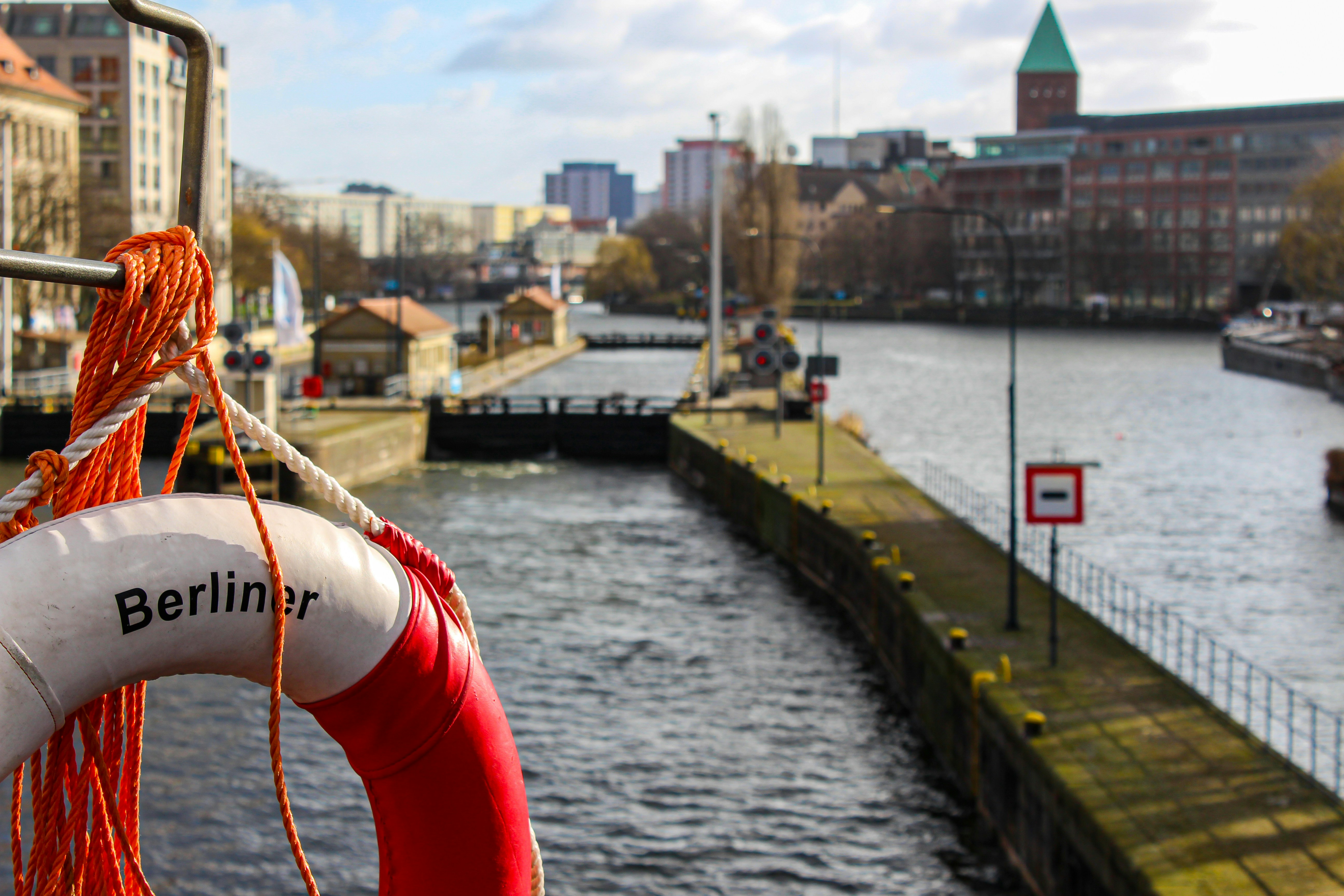 A red and white life preserver sitting next to a body of water photo ...