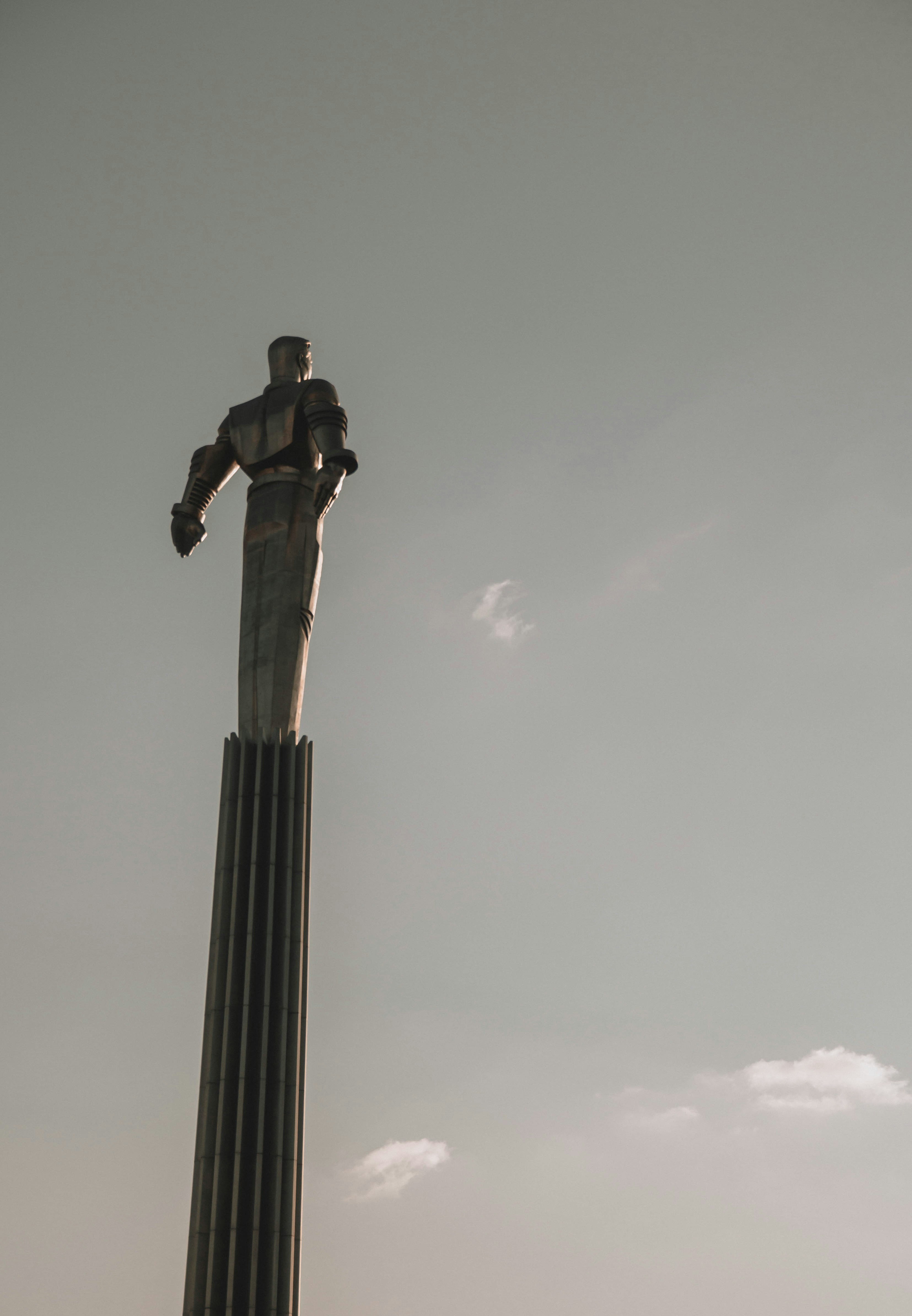 Foto zum Thema Eine Statue eines Mannes, der auf einem hohen Pfahl ...