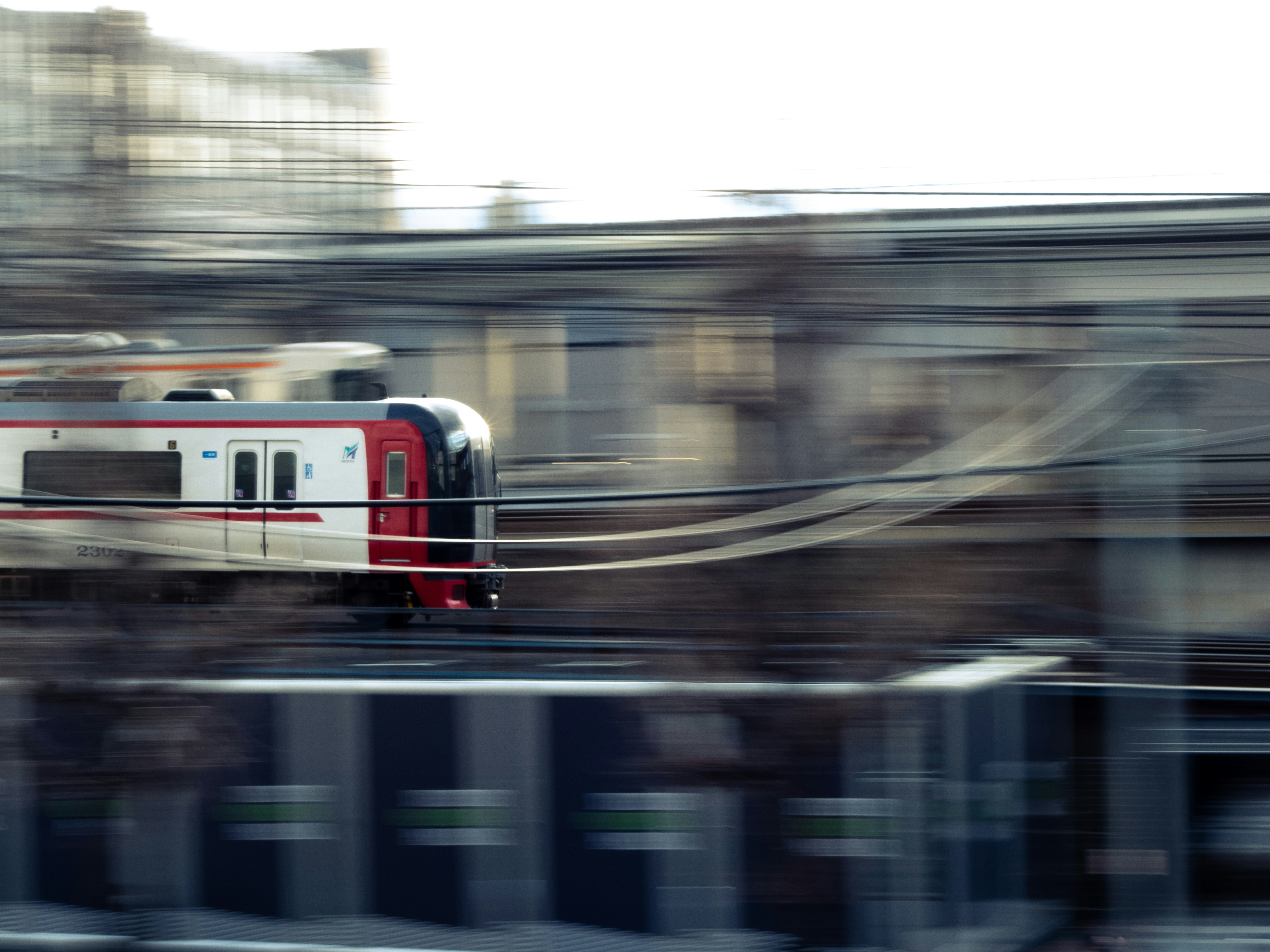 Un train rouge et blanc traversant une ville photo – Photo Former ...