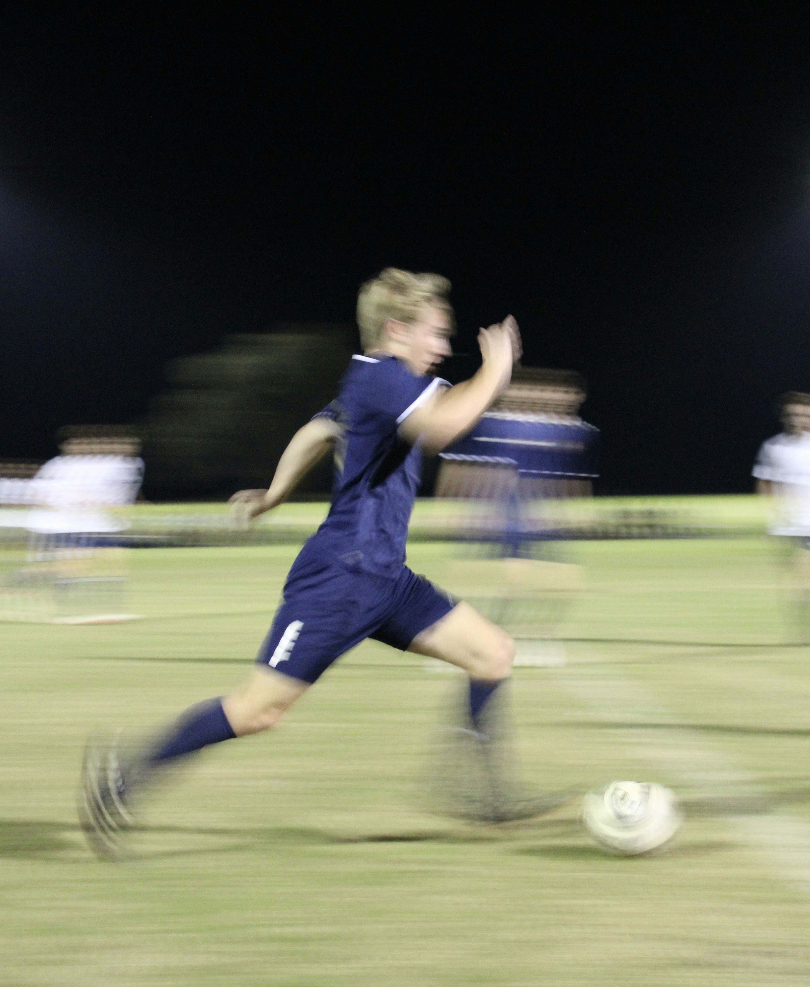 Midnight Sprint: Navy Kit Chases the Ball Under Stadium Lights
