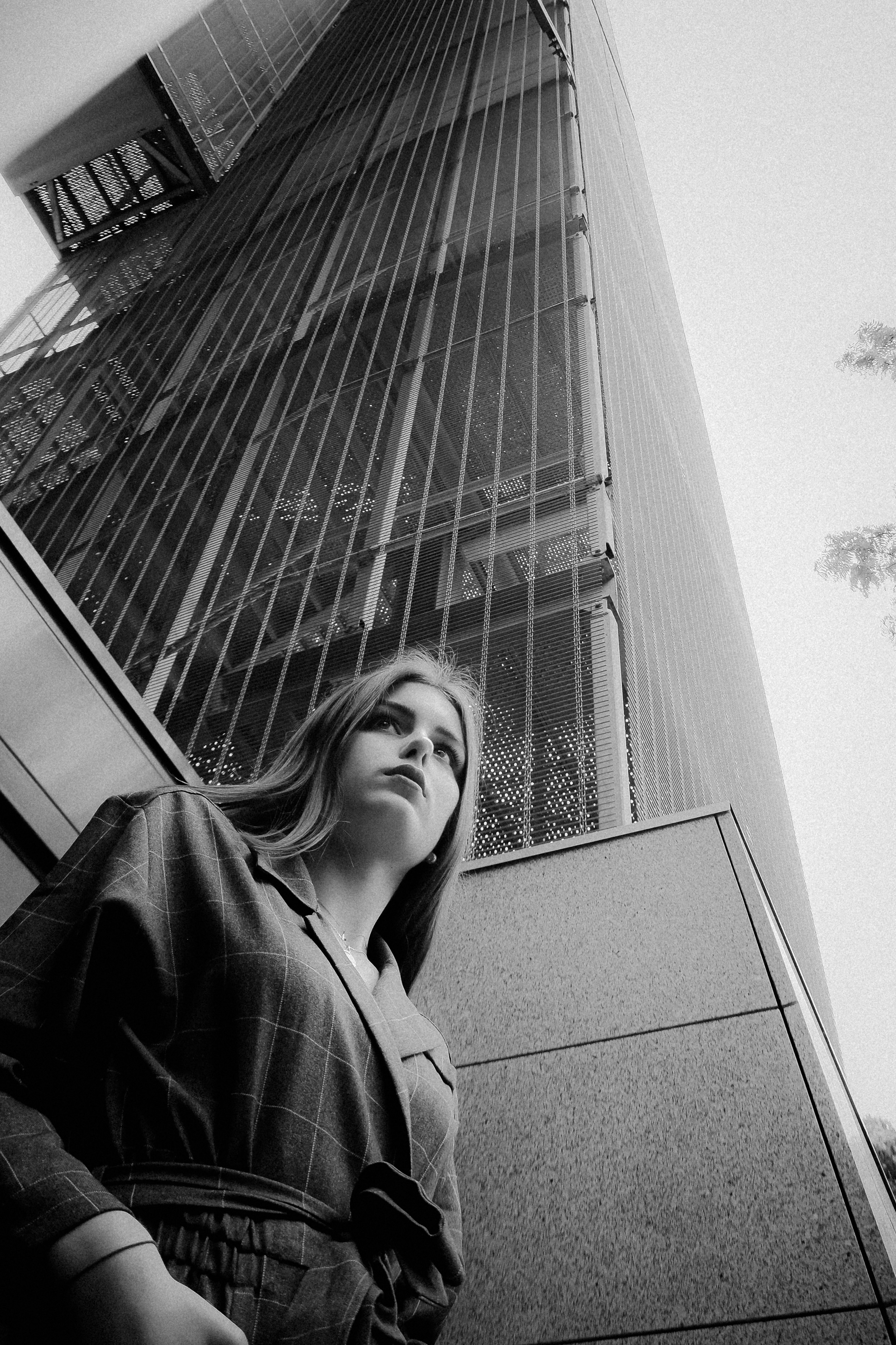 Gaze Beneath the Grid: A Low-Angle Portrait Against a Glass Tower