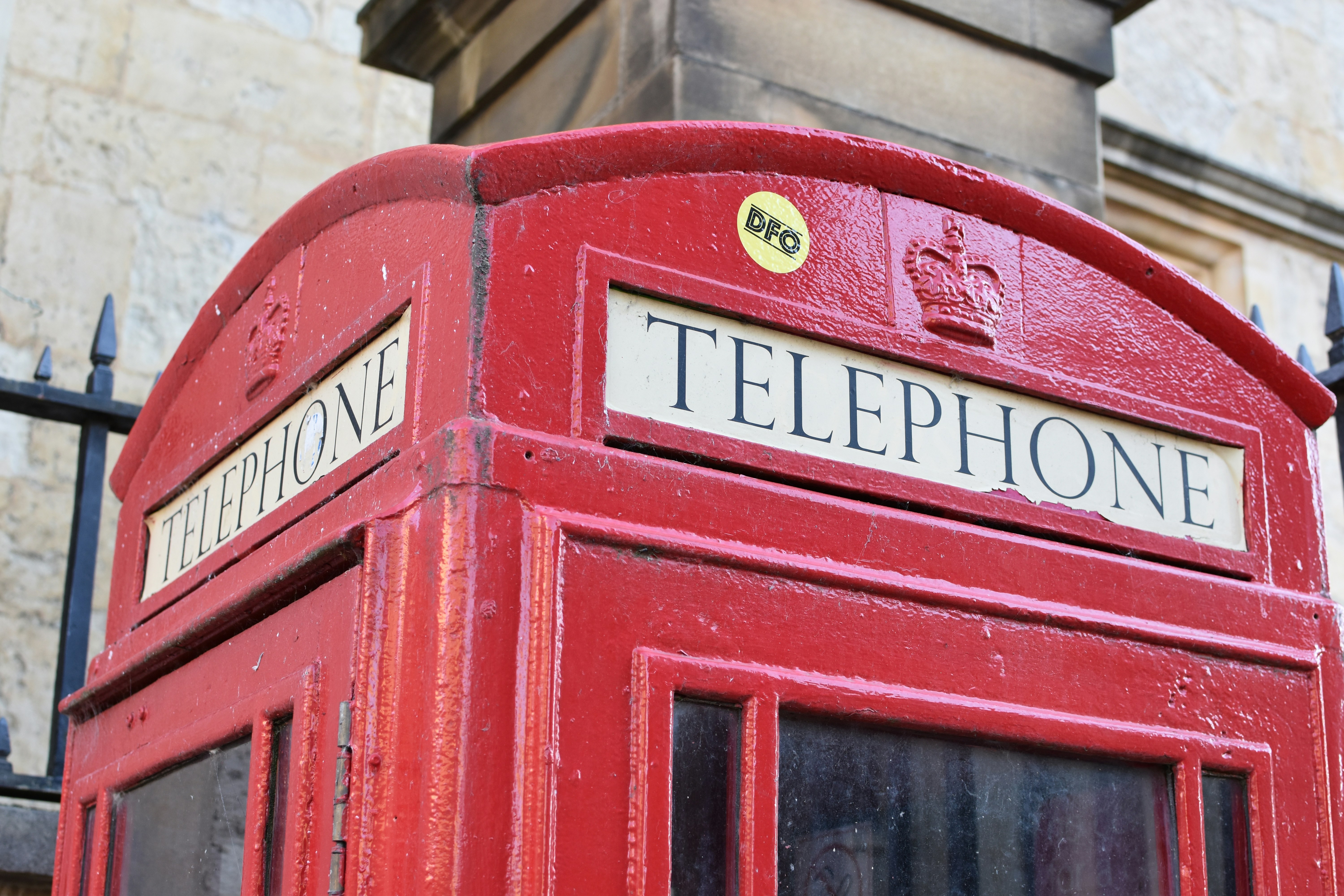 A red telephone booth in front of a building photo – Free Red Image on ...
