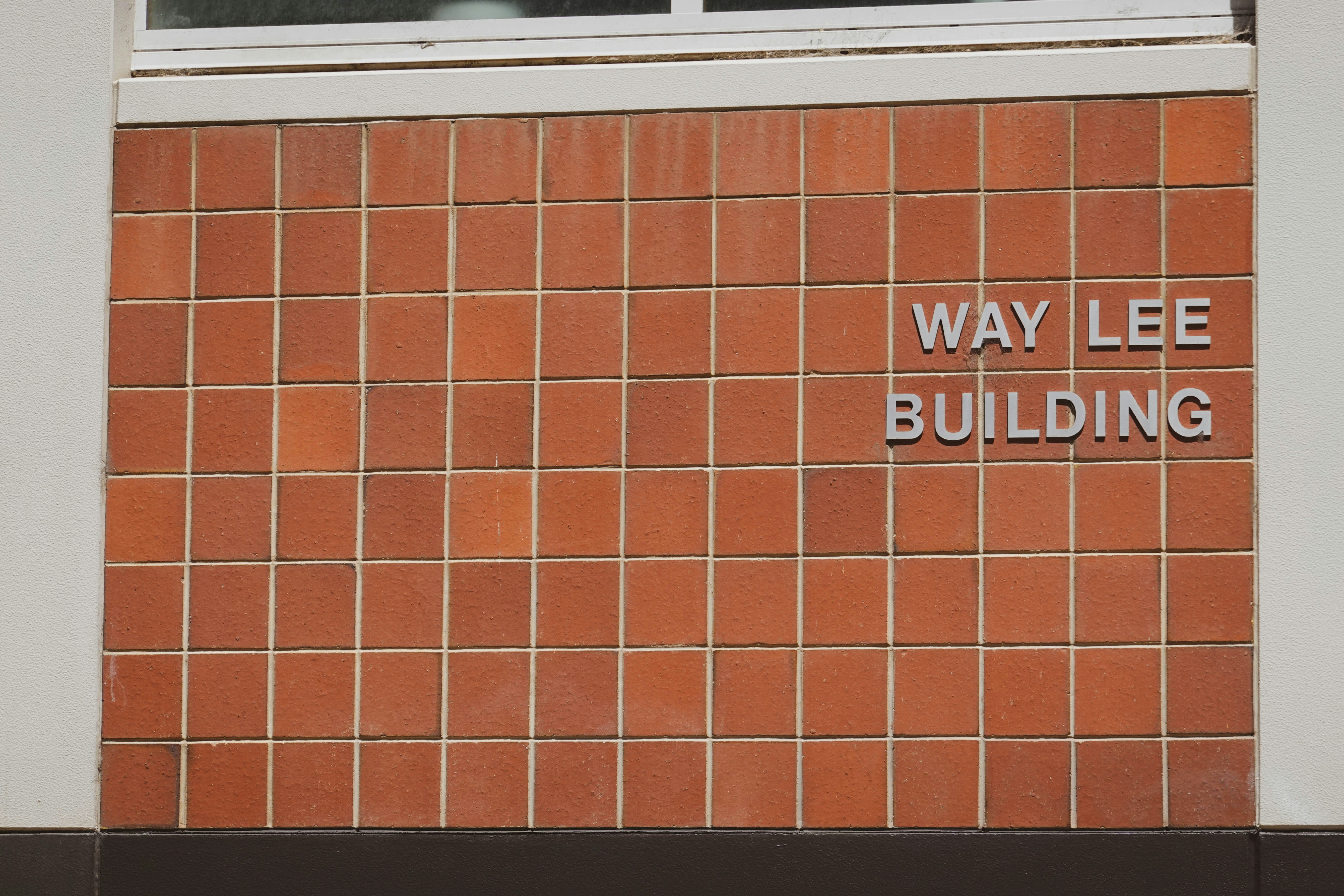 Un mur de briques avec un panneau qui dit Way Lee Building photo ...