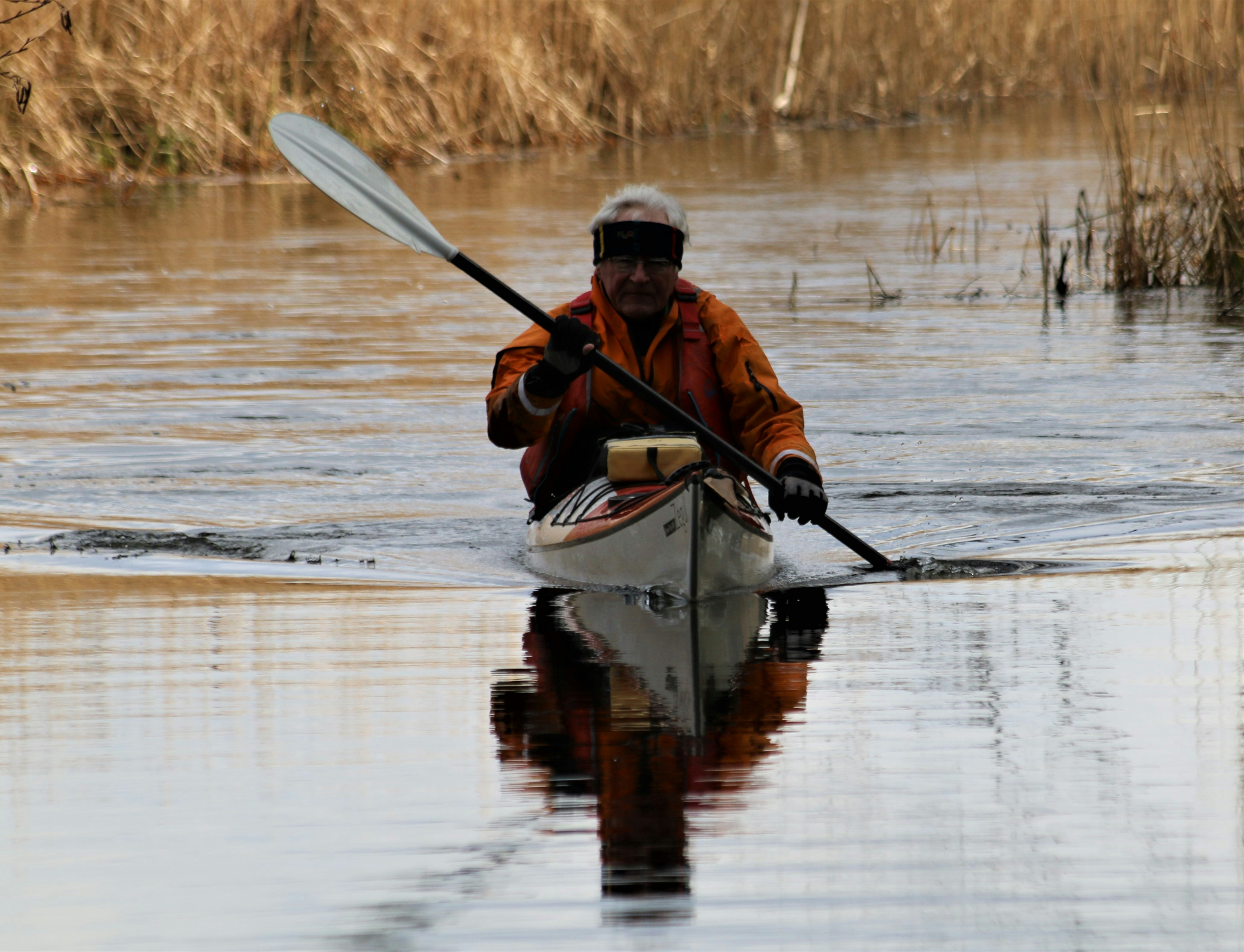 Canoeing in the canals | a man in an orange jacket paddling a kayak