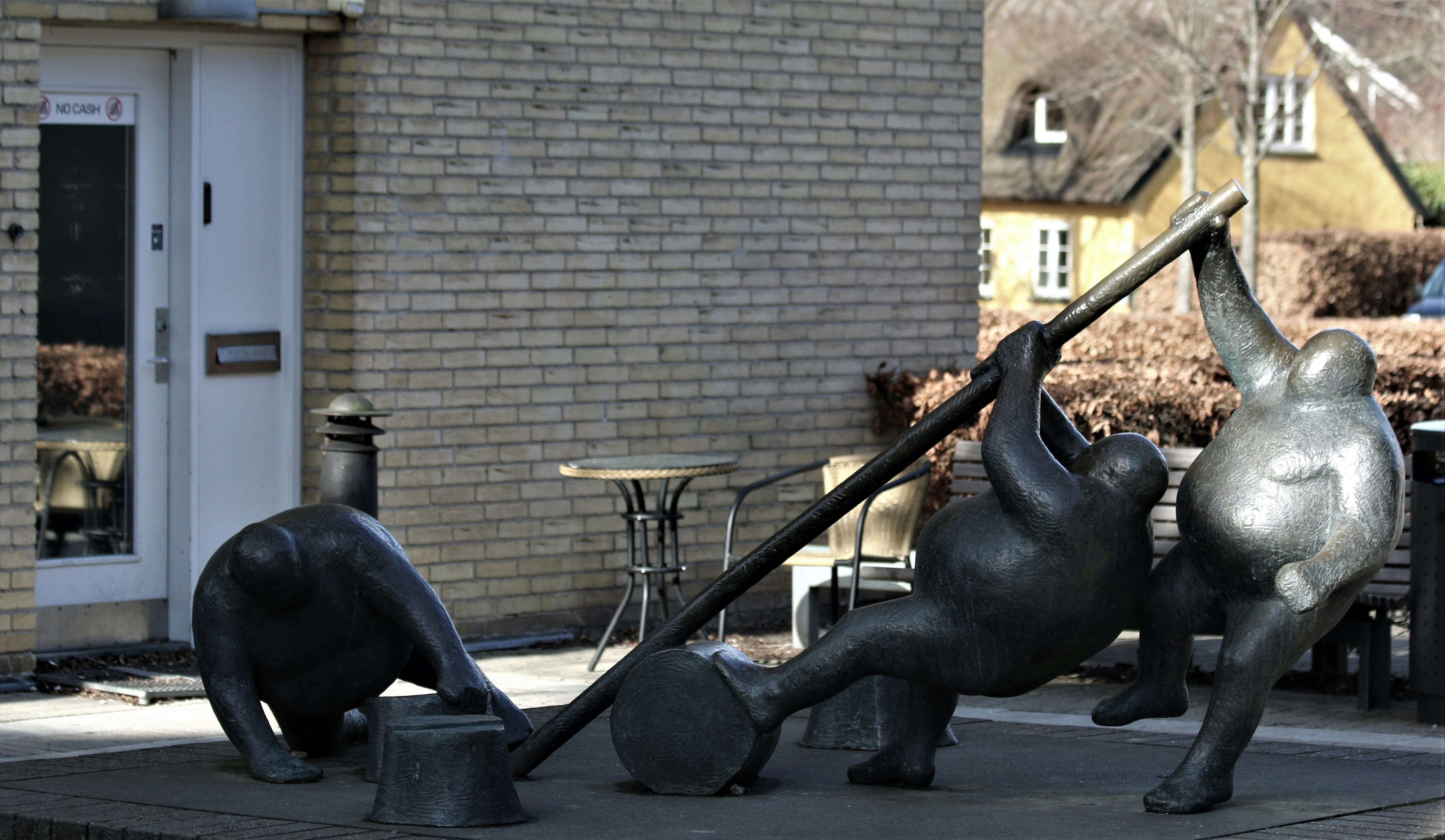 A statue of a man pushing a woman on his back photo – Free Art Image on ...