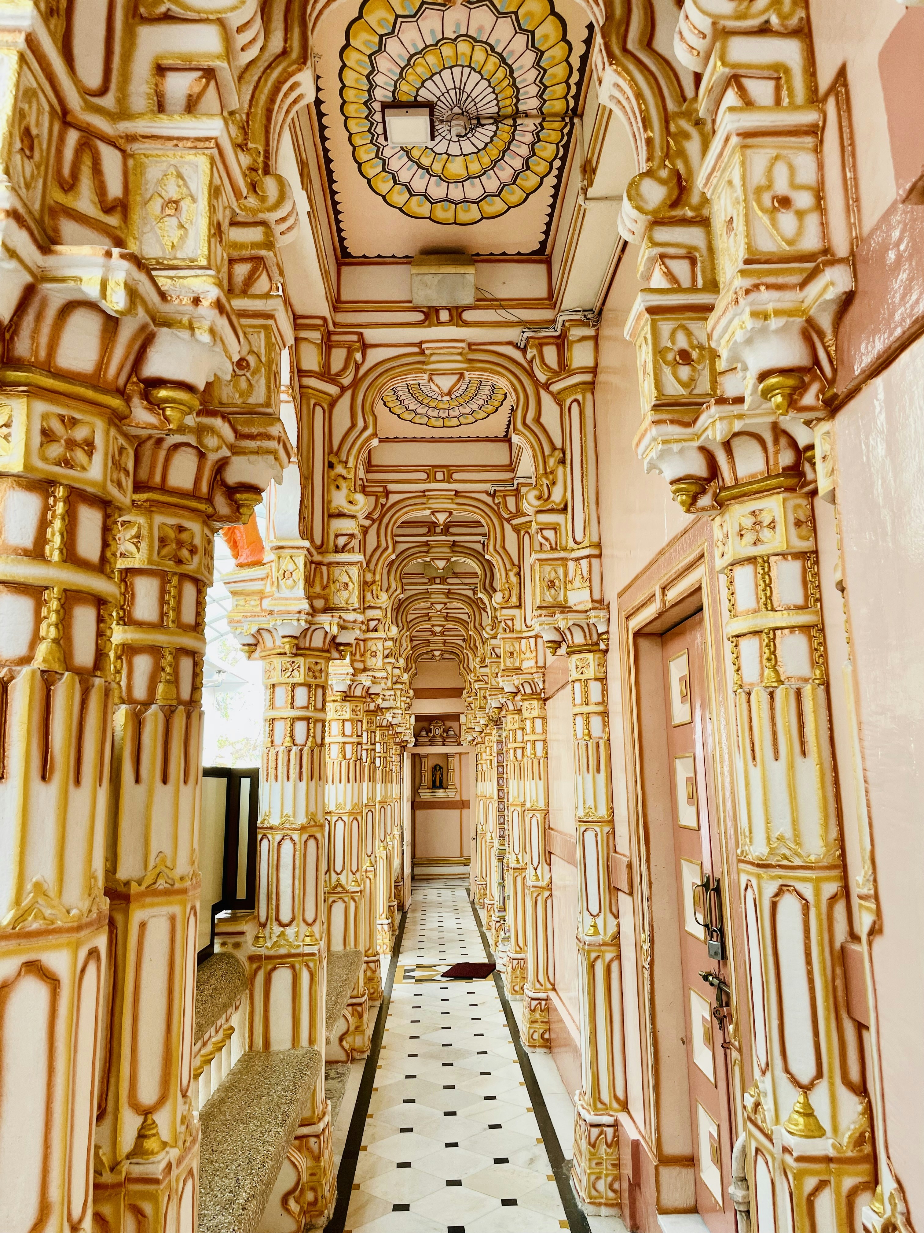 Echoes of Gold: Repeating Arches in a Pink-Gold Corridor