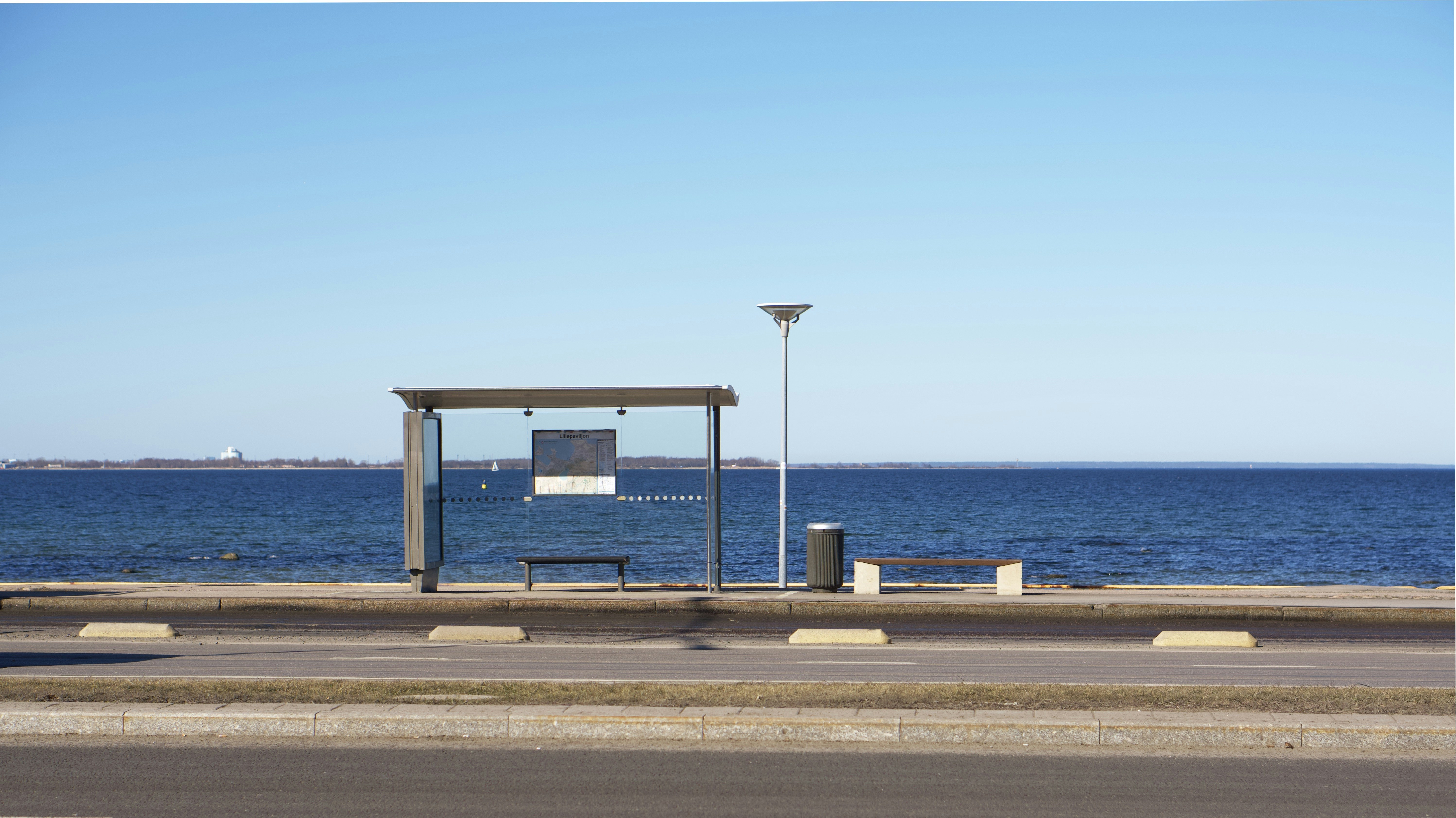 Minimalist Seaside Bus Stop Framed by a Calm Blue Horizon