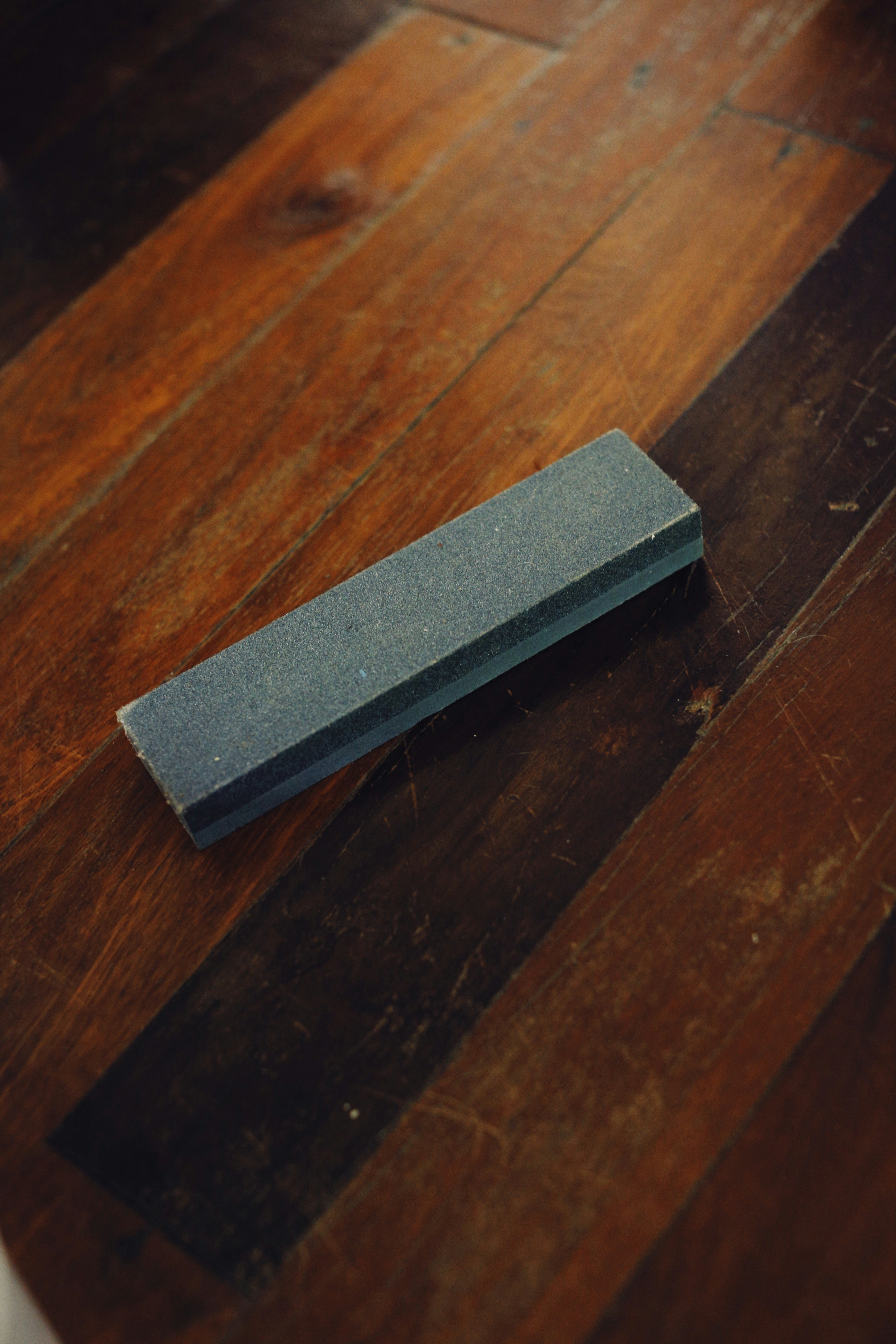 a piece of blue paper sitting on top of a wooden floor