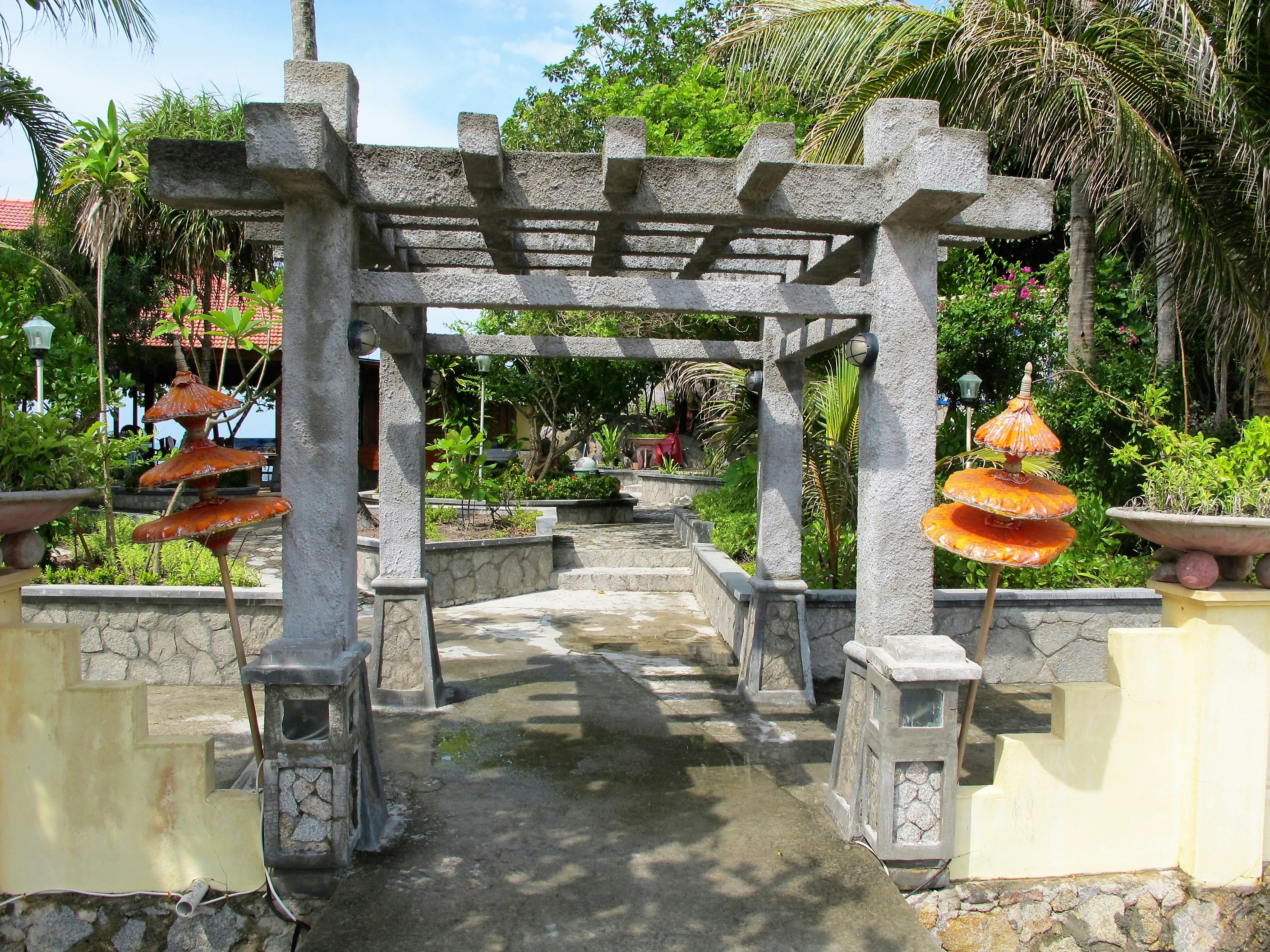 A stone structure with orange umbrellas hanging from it photo – Free ...