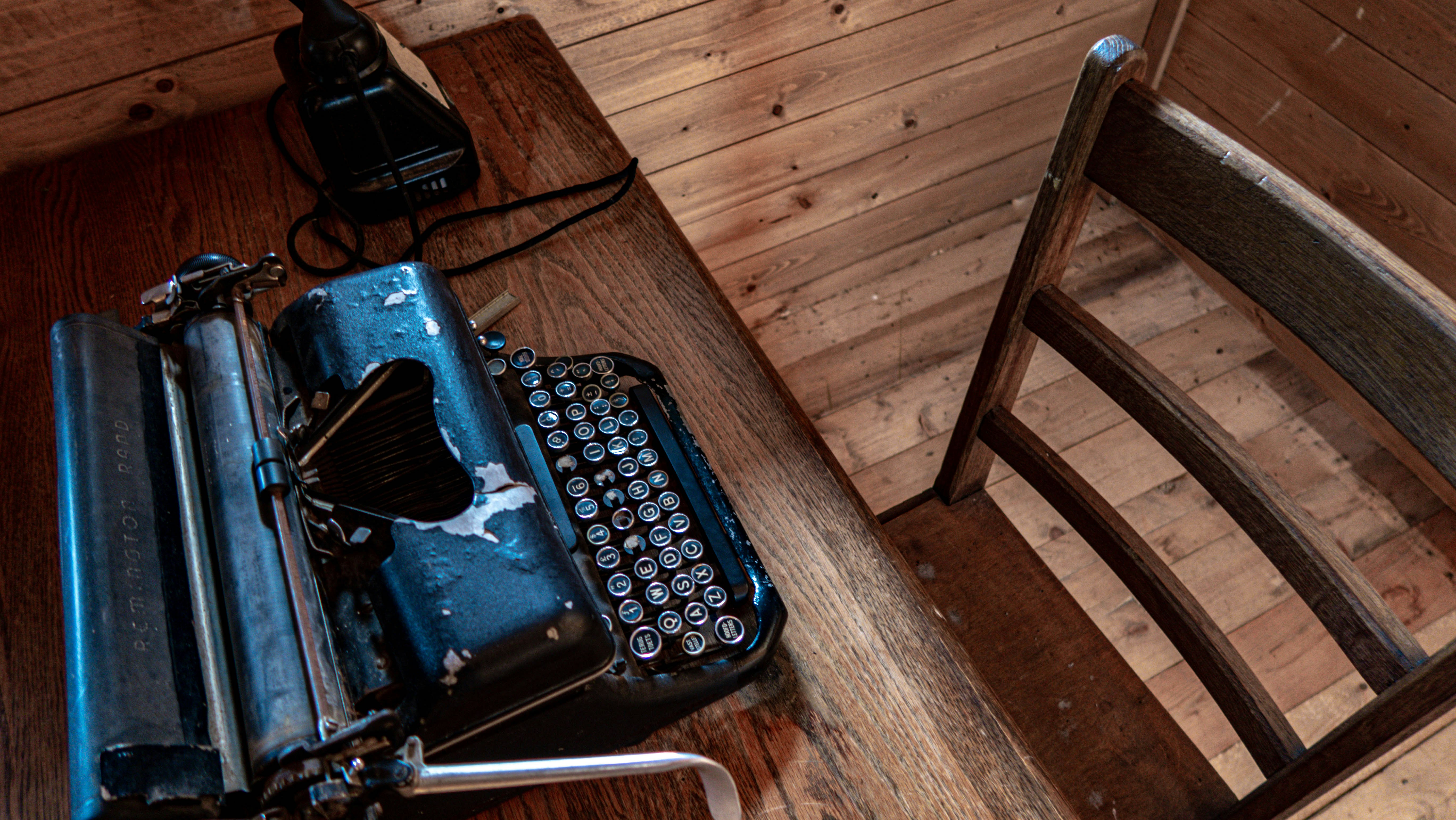 Vintage typewriter resting on a wooden table in a rustic cabin, evoking nostalgia and creativity.