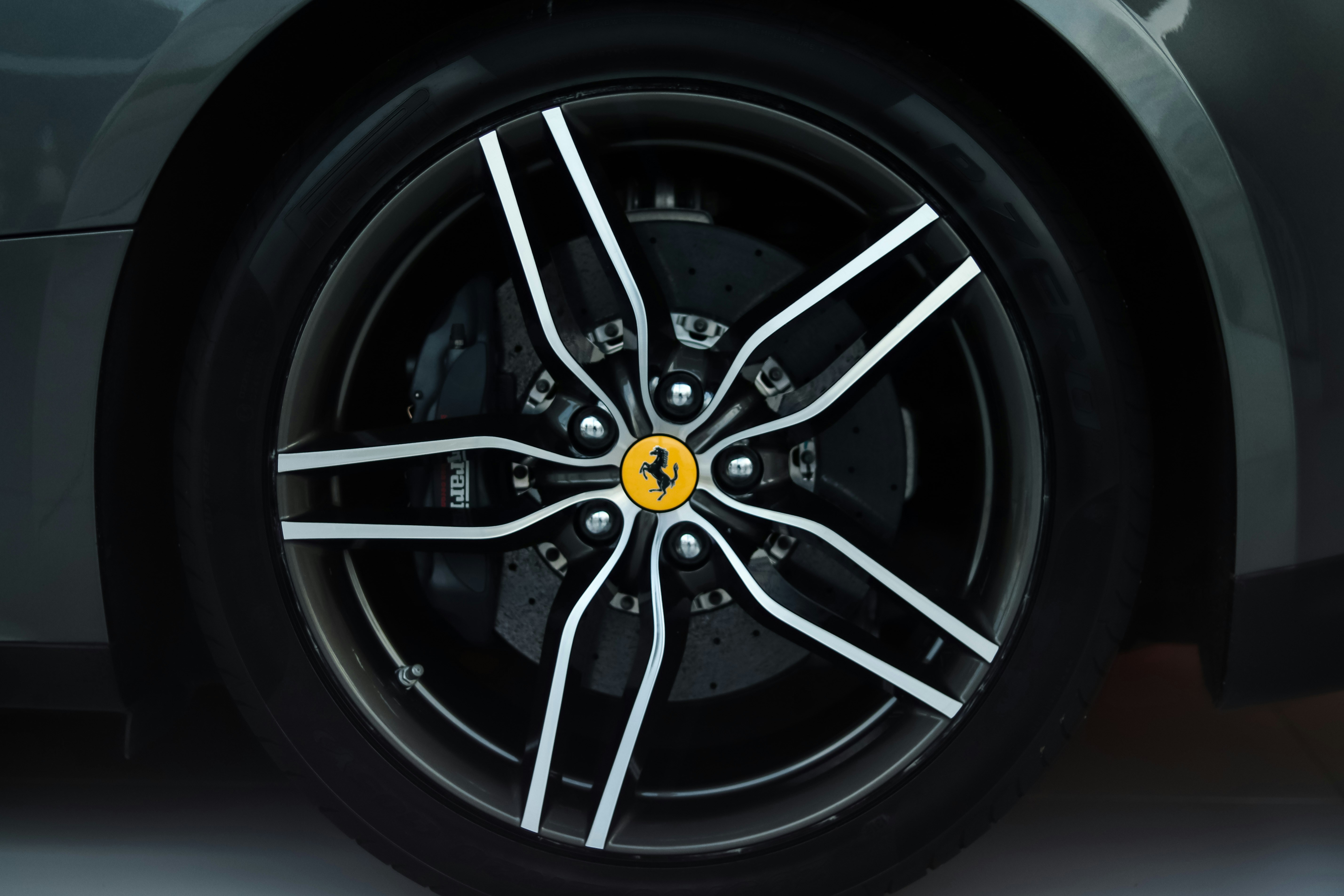 Close-Up of Ferrari Wheel: Silver Spoke Geometry Framing the Yellow Crest