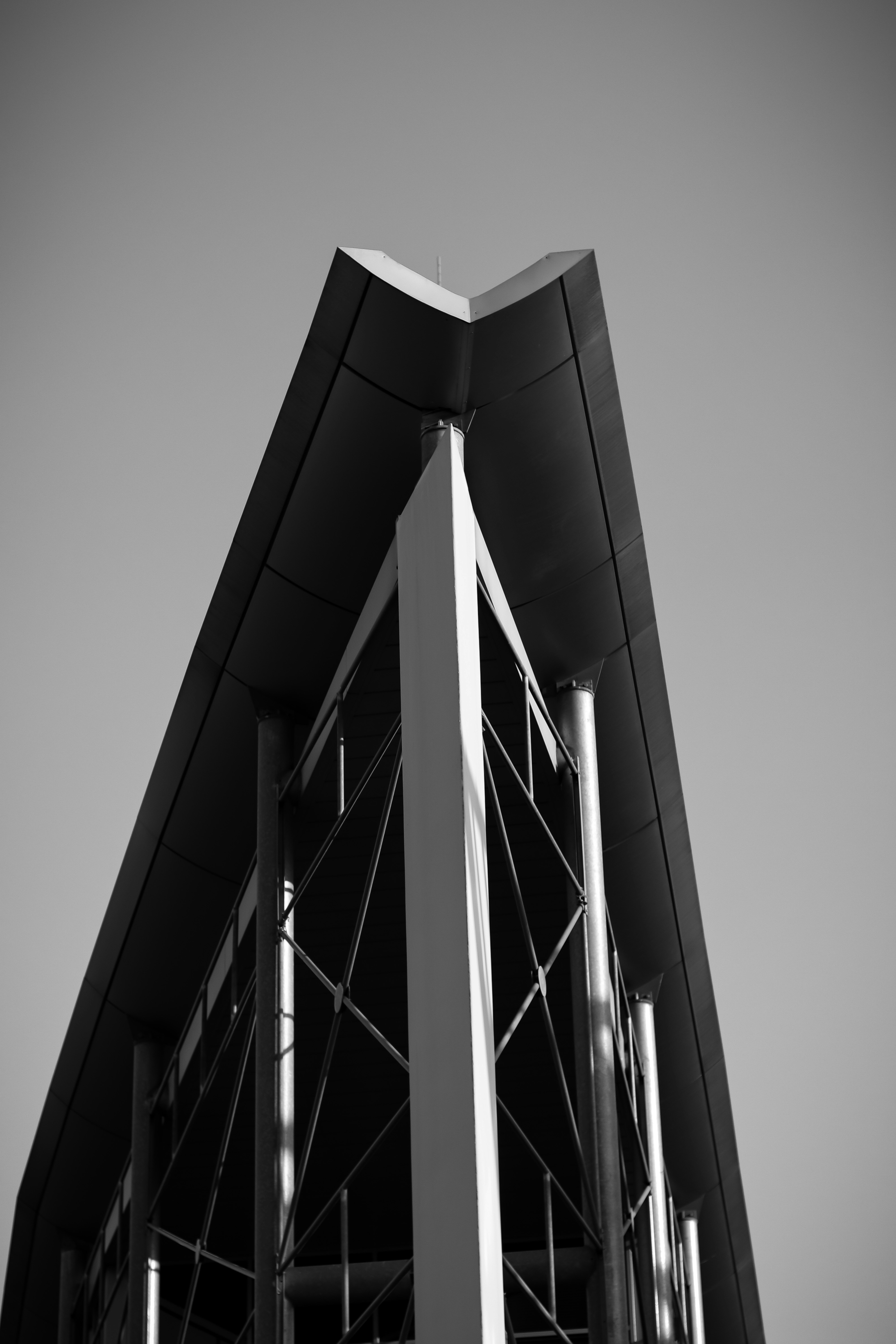 Angular rooftop of a contemporary building captured in monochrome, highlighting geometric lines and structural elements.