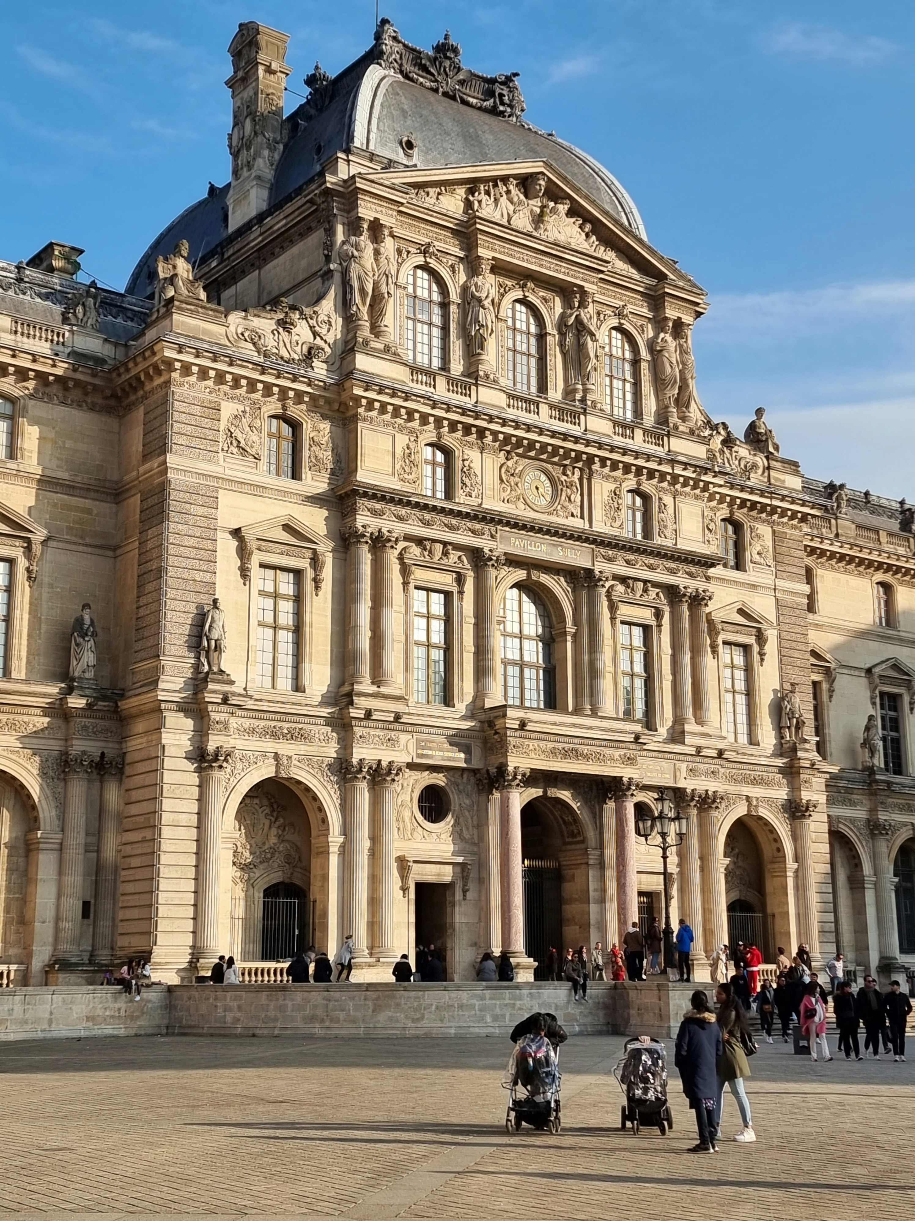 A group of people standing in front of a large building photo – Free ...