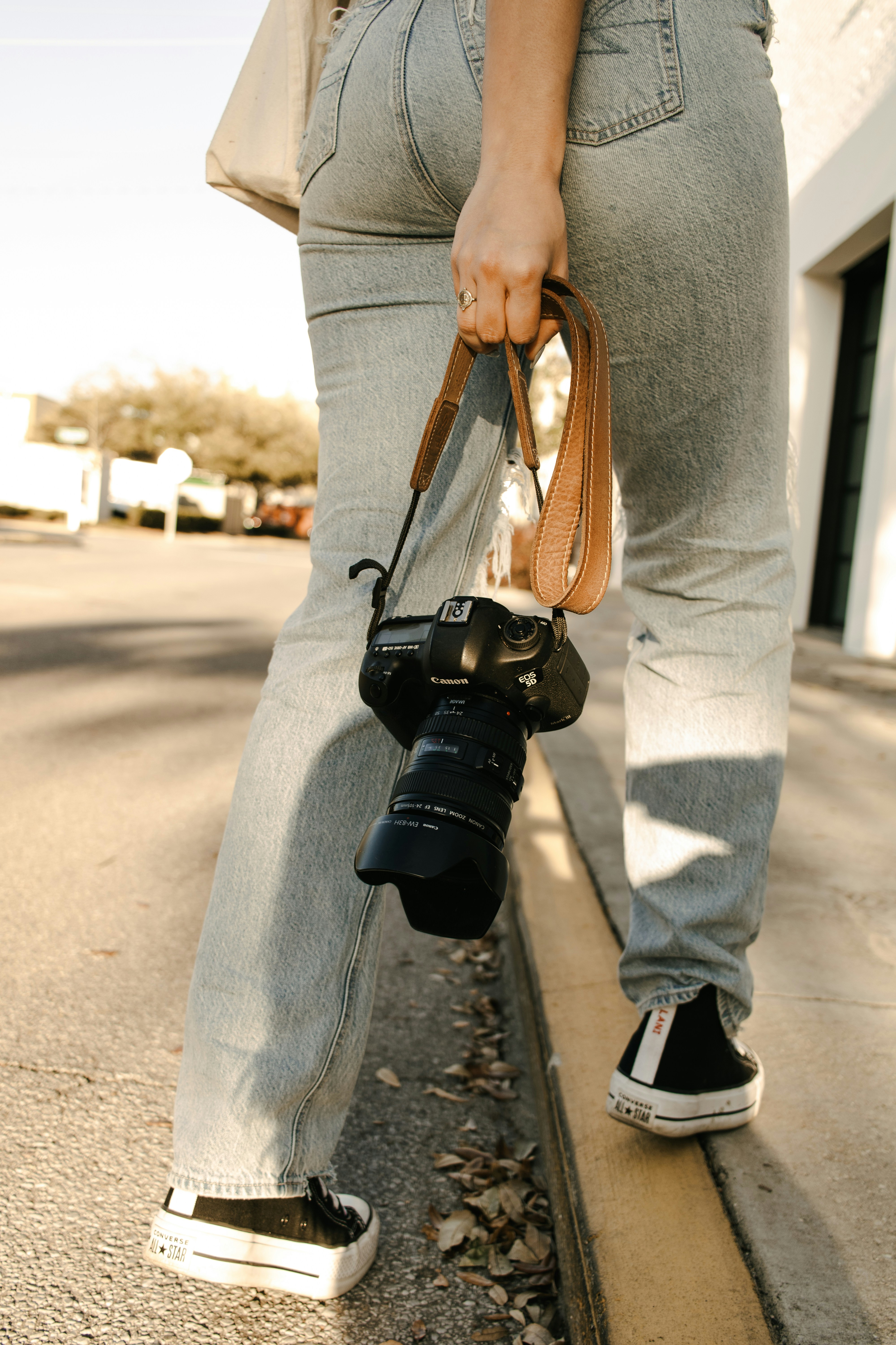 Caught in Focus: A Photographer's Pathway with a Camera Slung from the Hand