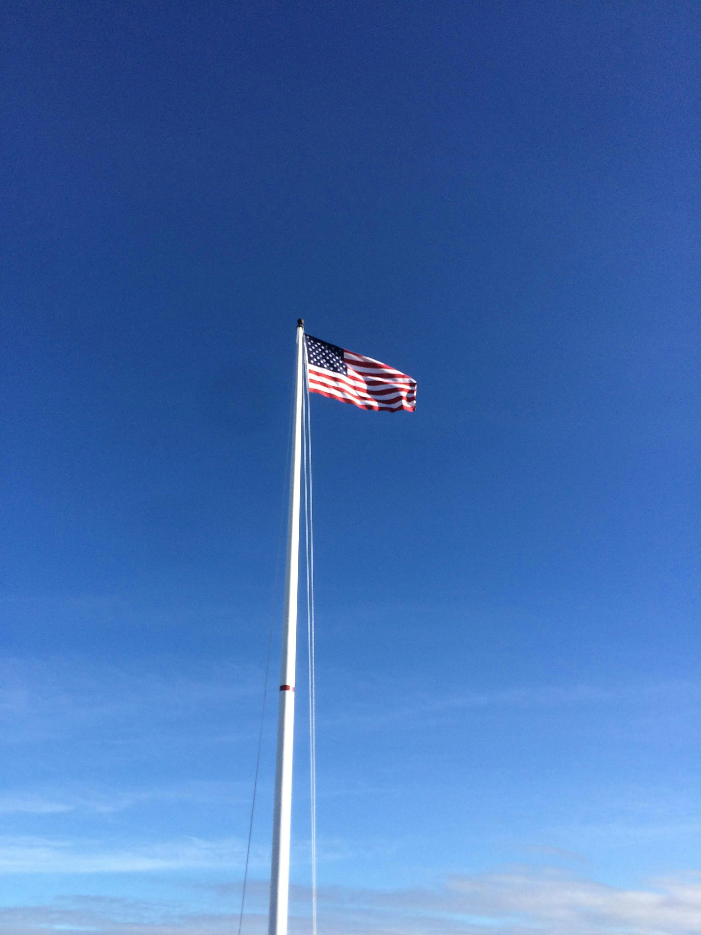 American flag waving proudly against a clear blue sky.