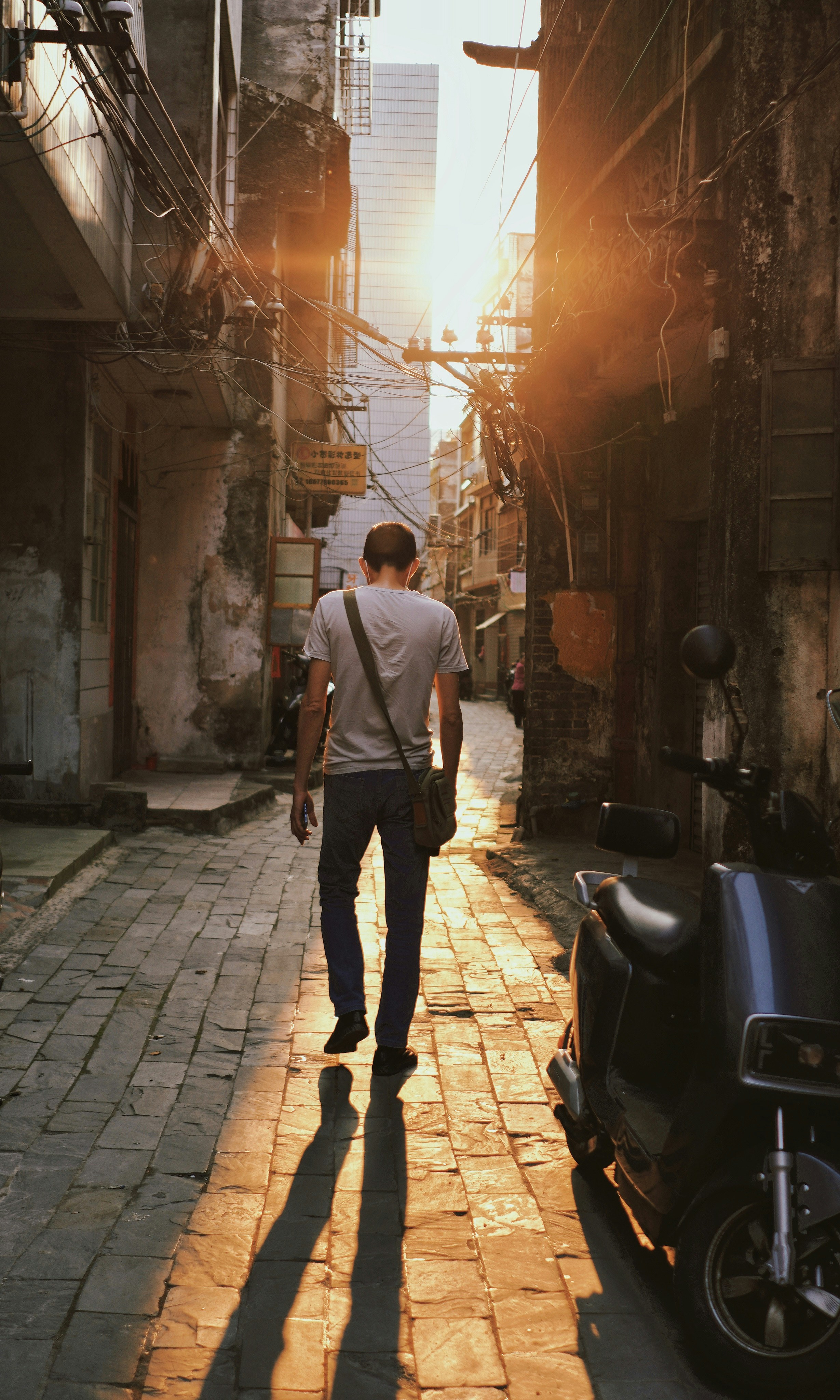 A man walking down a street next to a motorcycle photo – Free Shoe ...