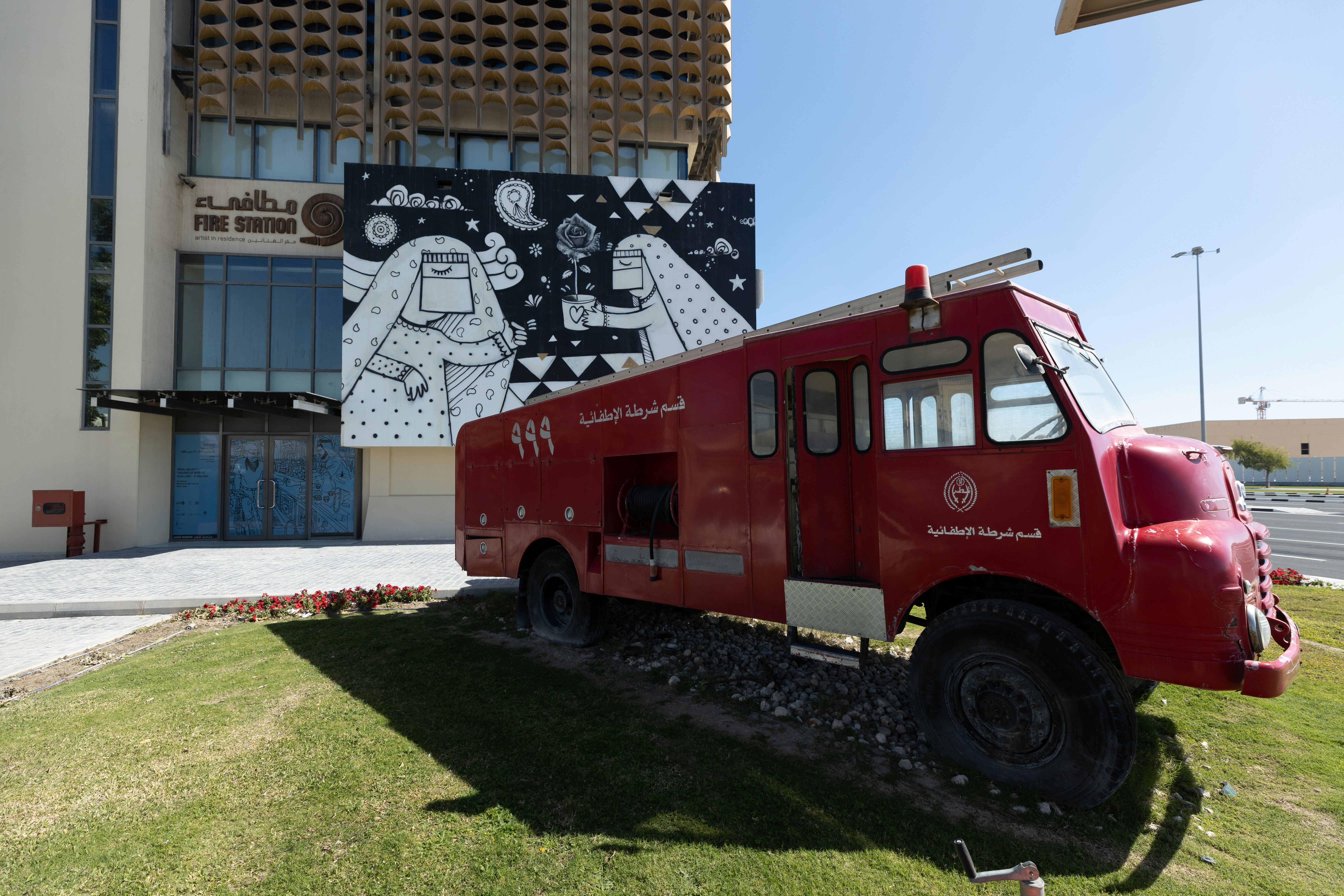 A red fire truck parked in front of a building photo – Free Qatar Image ...