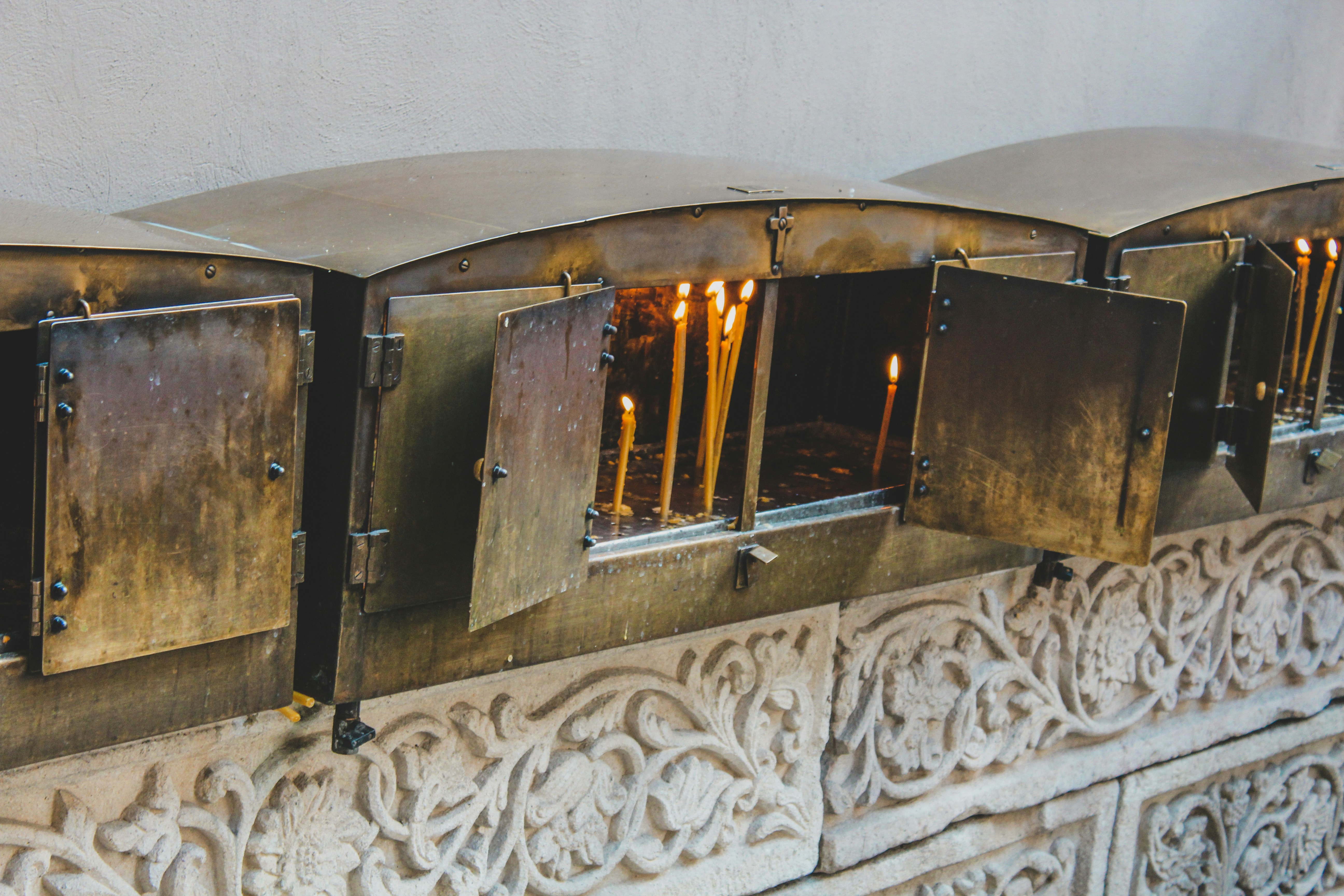 Candlelit Row of Weathered Mailboxes on Ornate Stonework