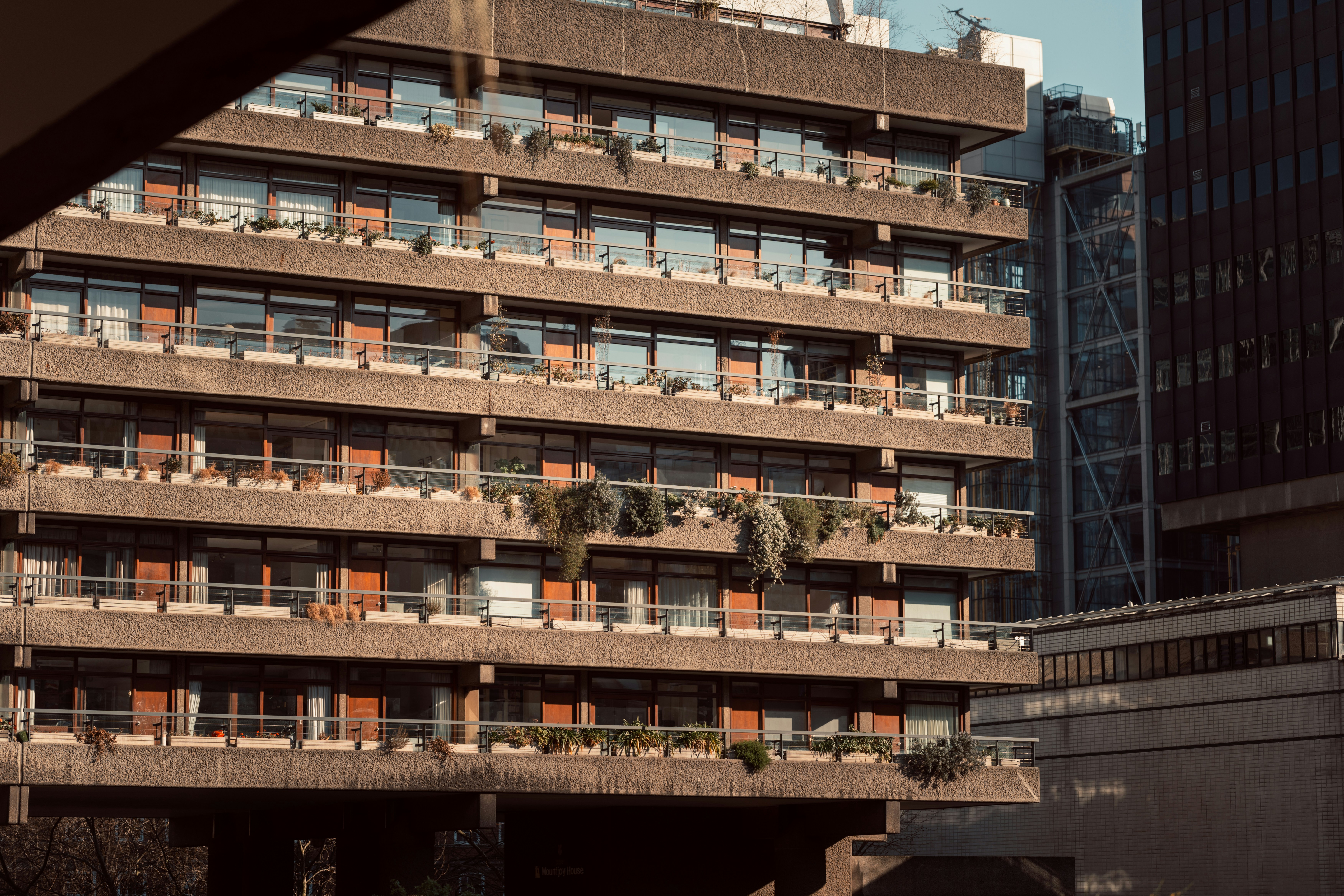 Foto Un edificio alto con balcones y plantas en los balcones – Imagen Barbacana gratis en Unsplash