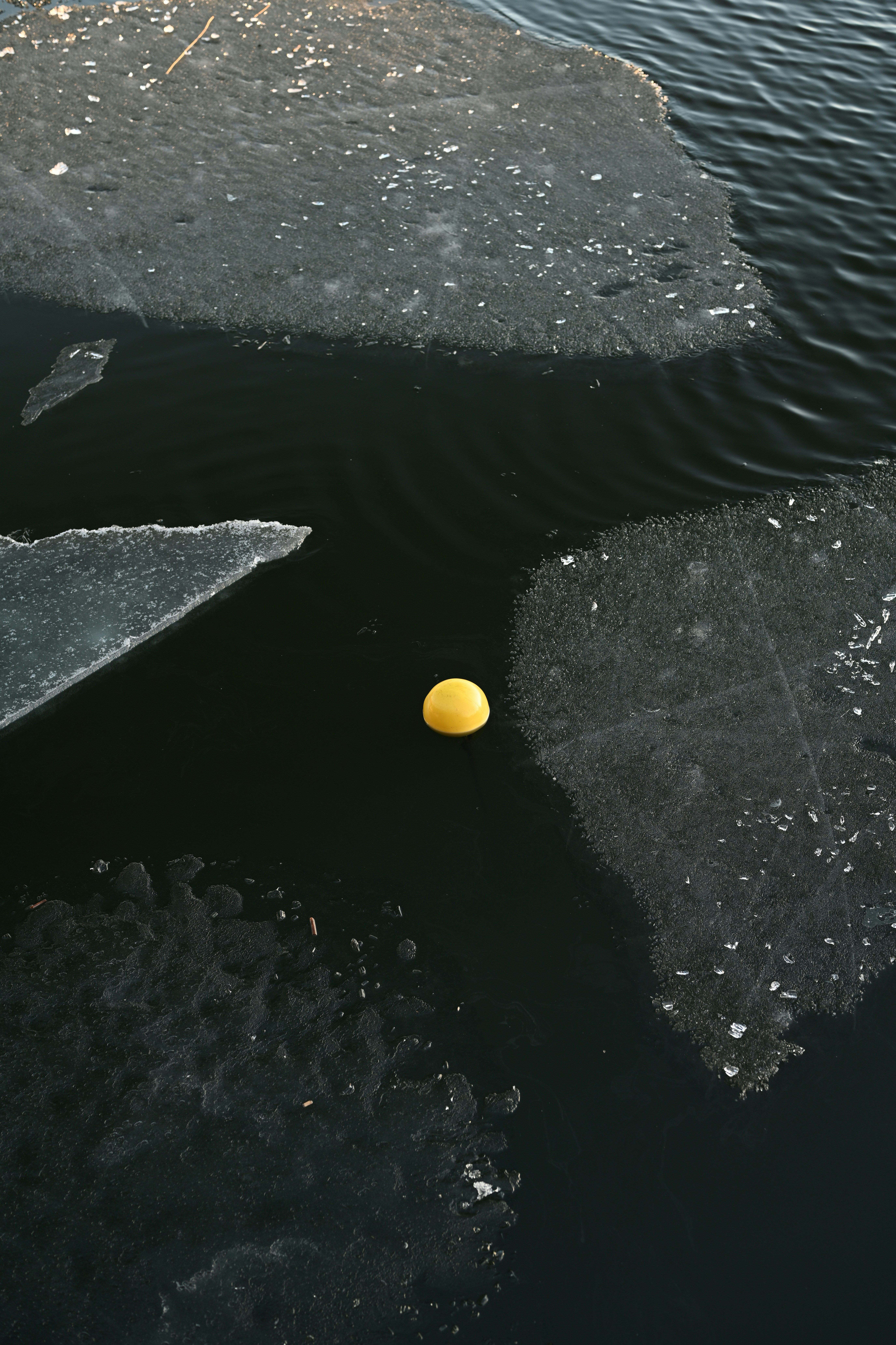 A yellow object floating on top of a body of water photo – Free Grey ...