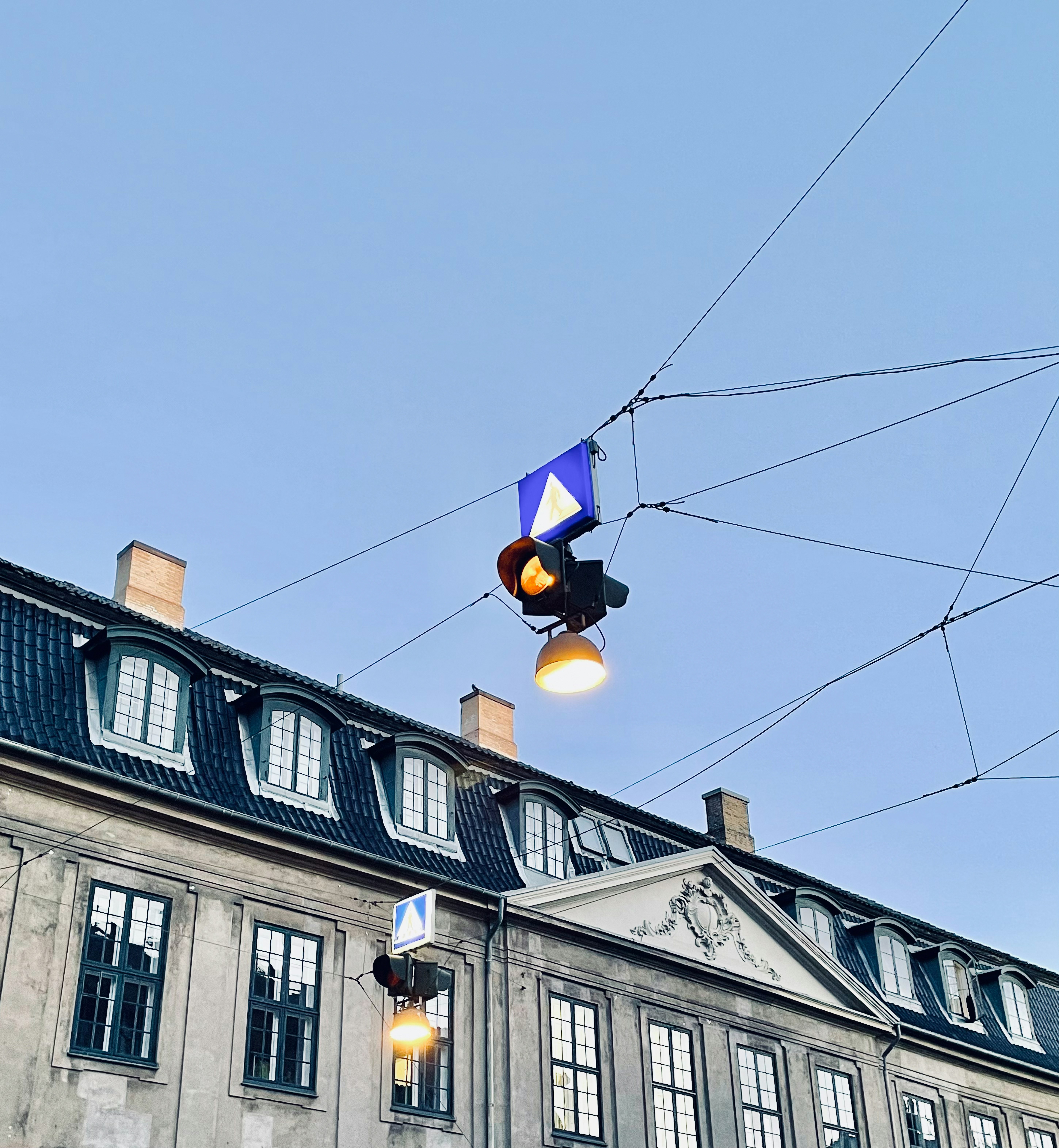 Pedestrian crossing light hanging in front of Copenhagen apartment building