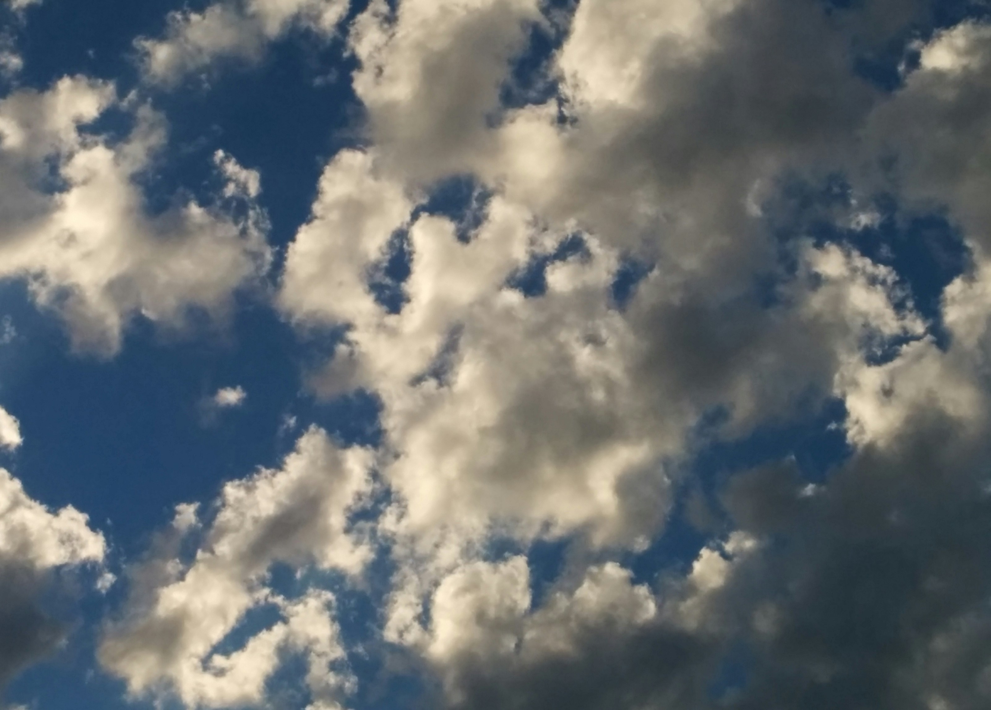 Fluffy clouds scattered across a deep blue sky, creating a serene atmosphere.