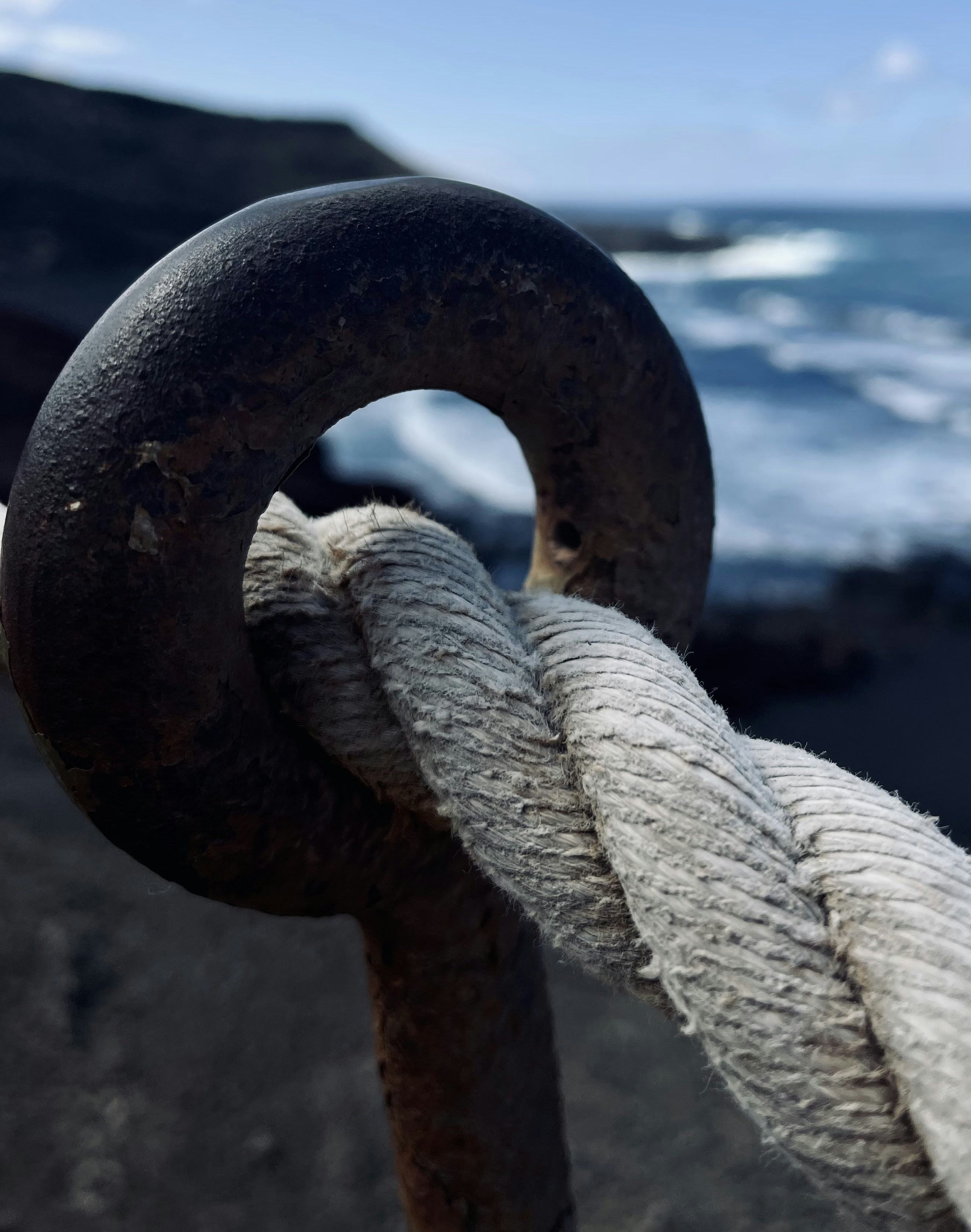 Tethered in Focus: Close-Up of Rope and Rust with Sea Backdrop