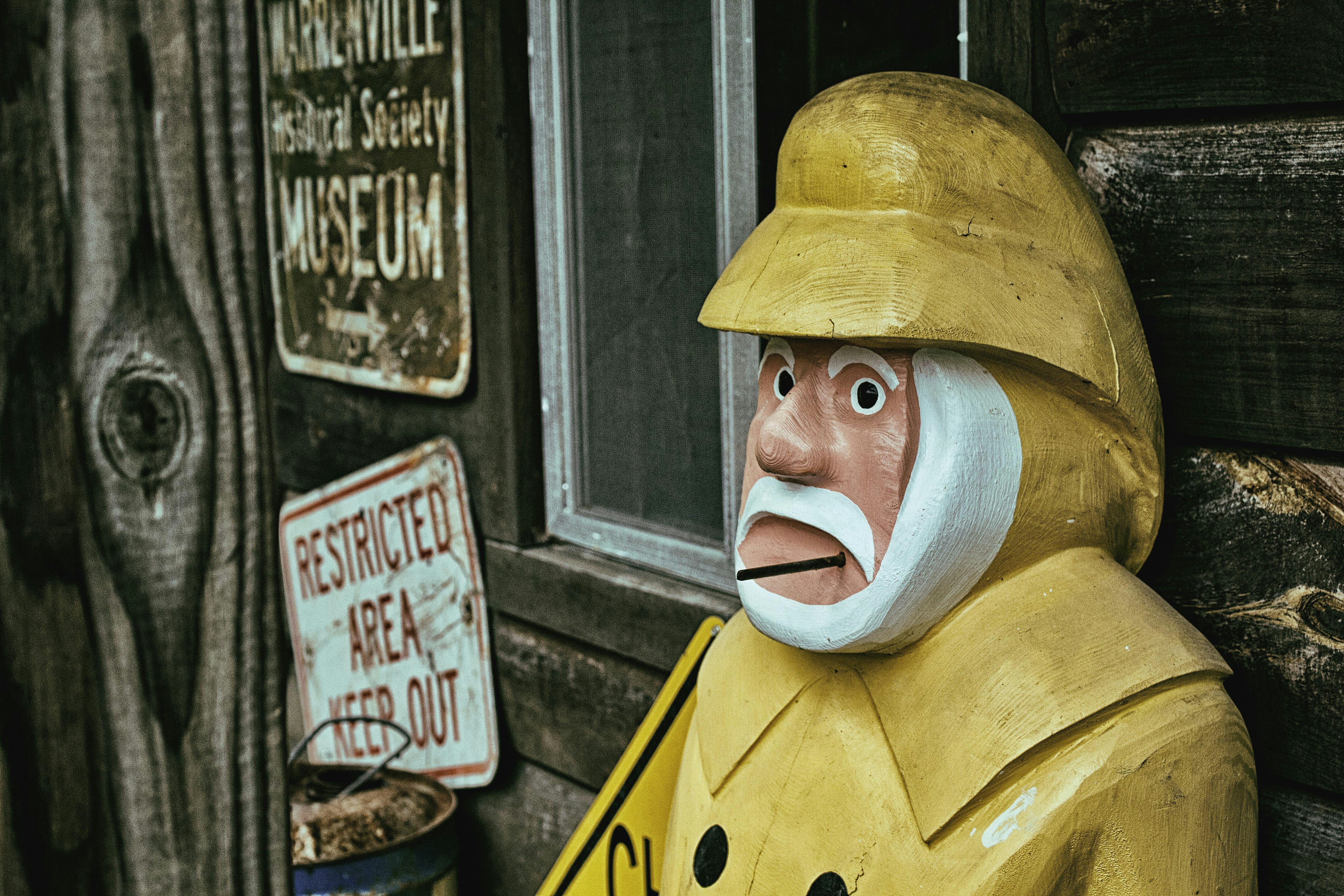 A statue of a man wearing a yellow raincoat photo – Free Rain suit ...