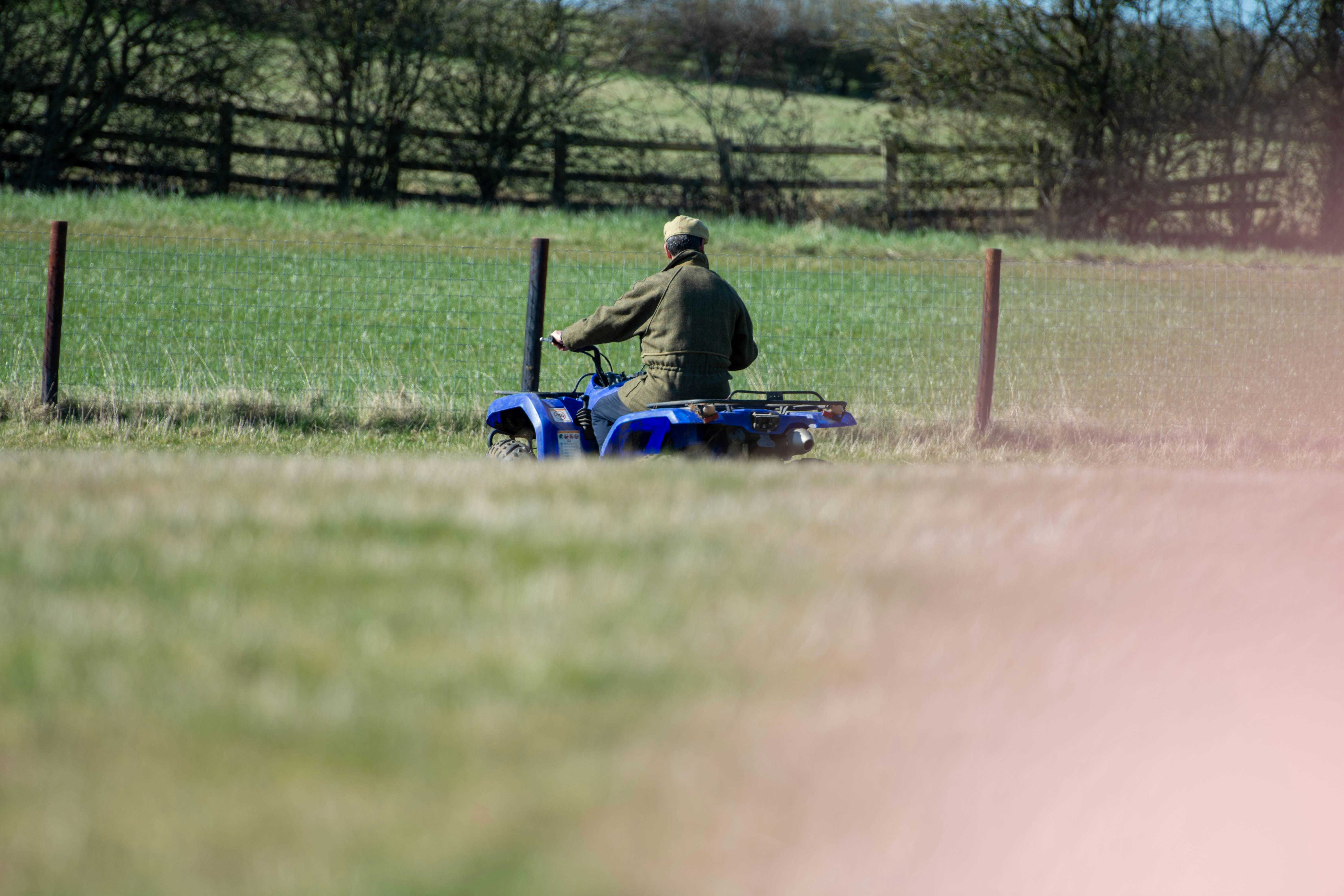 Blue Tractor Crossing: A Lone Rider in a Quiet Meadow
