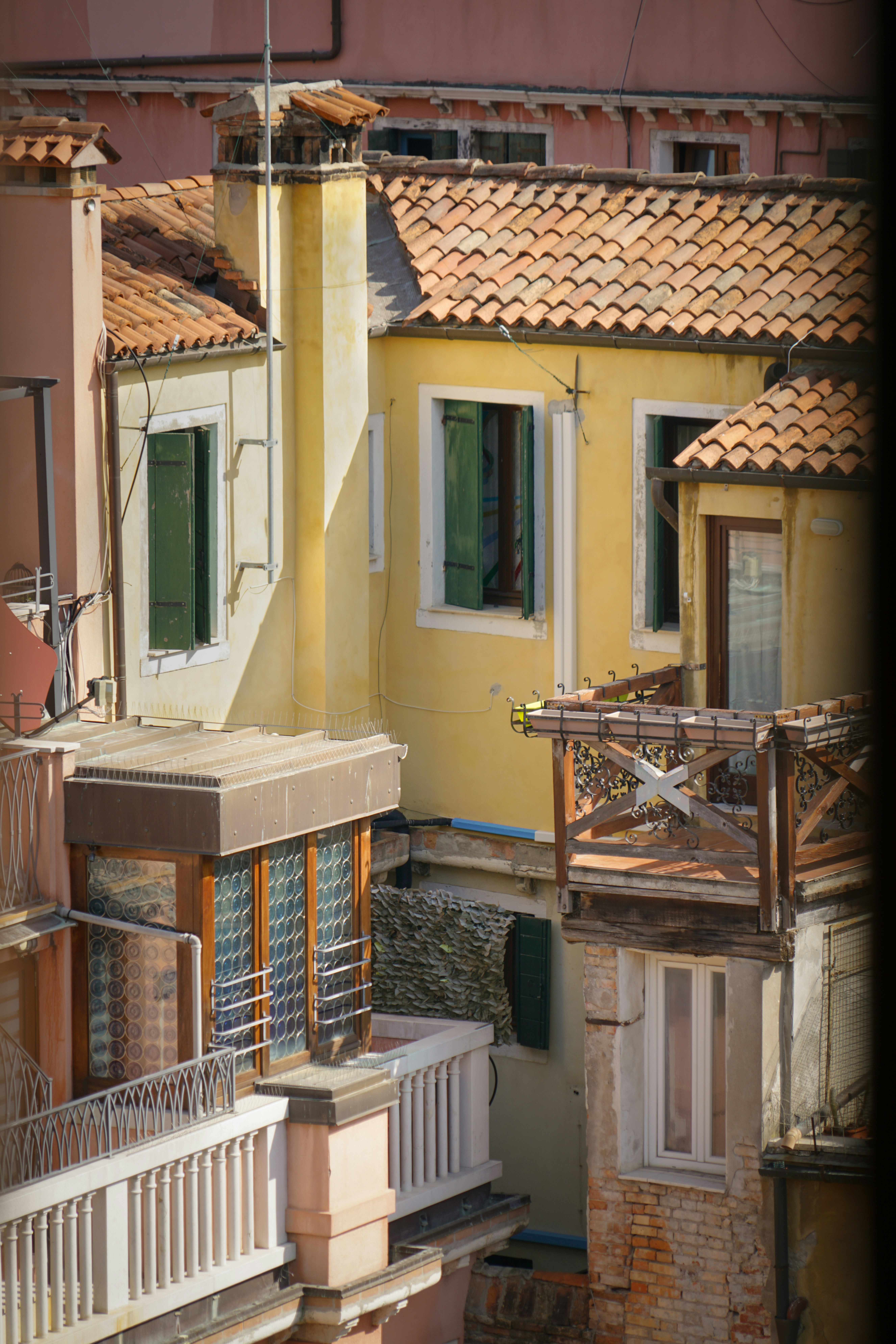 Sunlit Courtyard Chorus: Yellow Facades, Green Shutters, and Terracotta Tiles